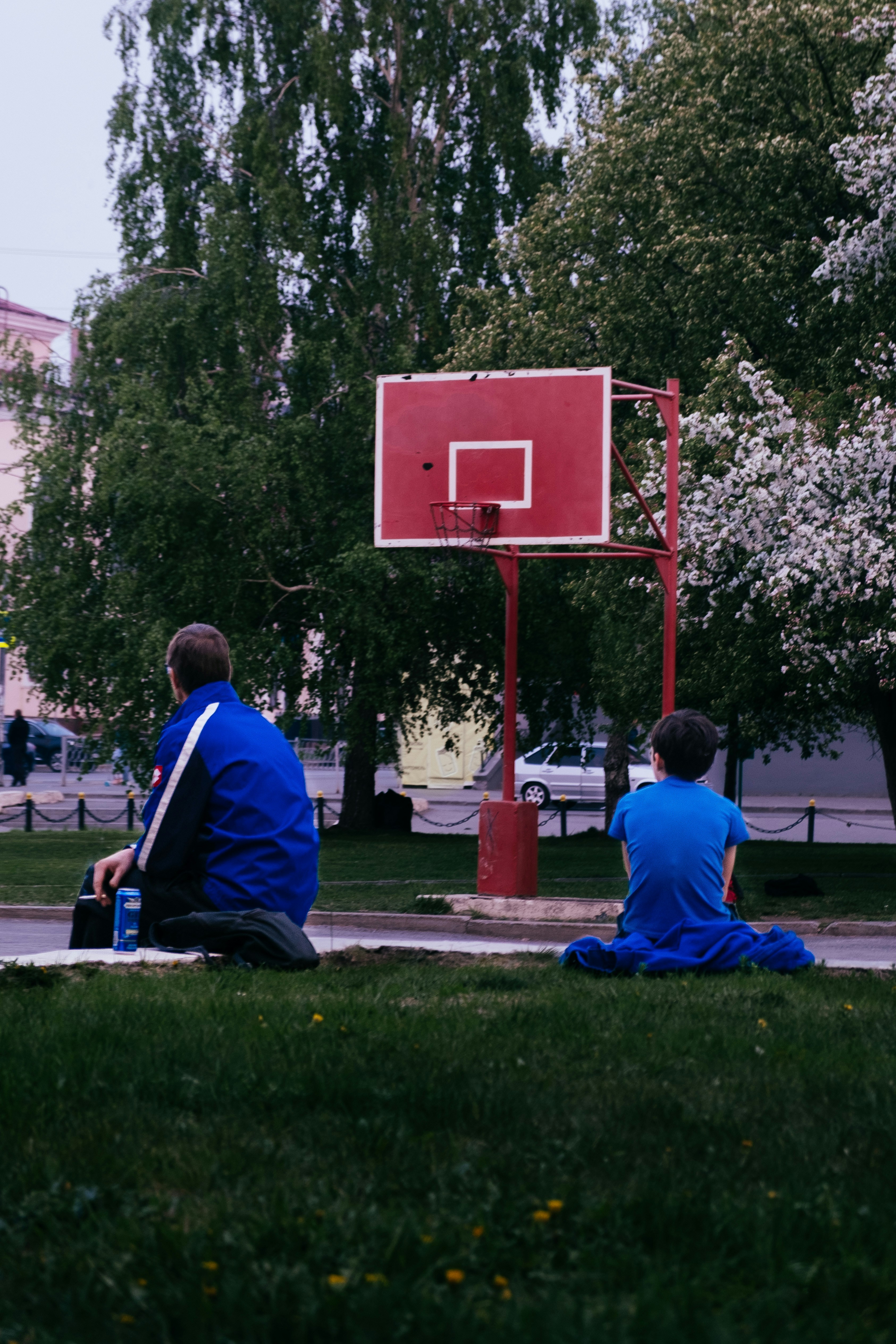 Crimson Hoop at Dusk: Quiet Park, Two Figures in Blue
