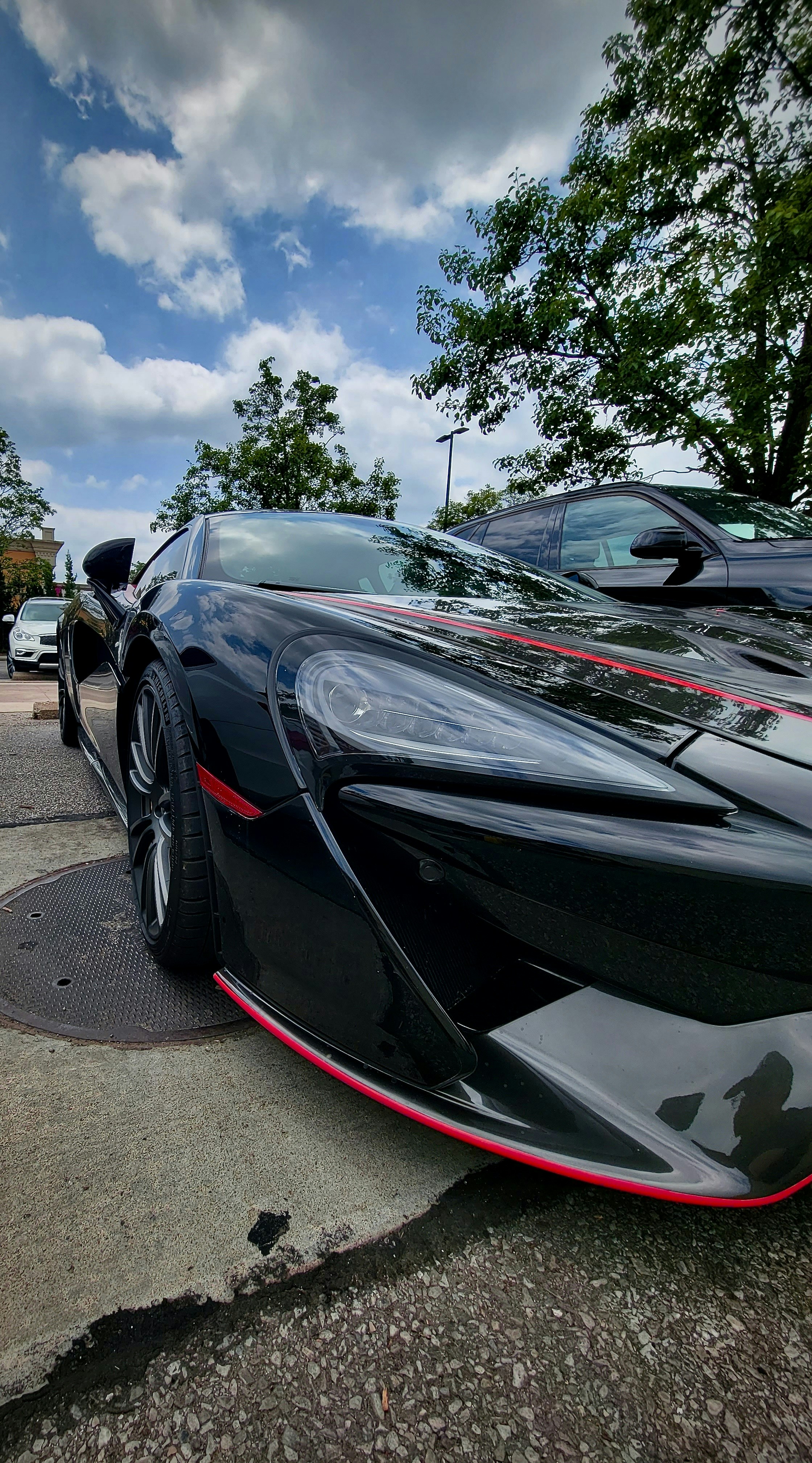 Red-Trim Shadow: A Low-Angle Portrait of a Black Hypercar in the Parking Lot