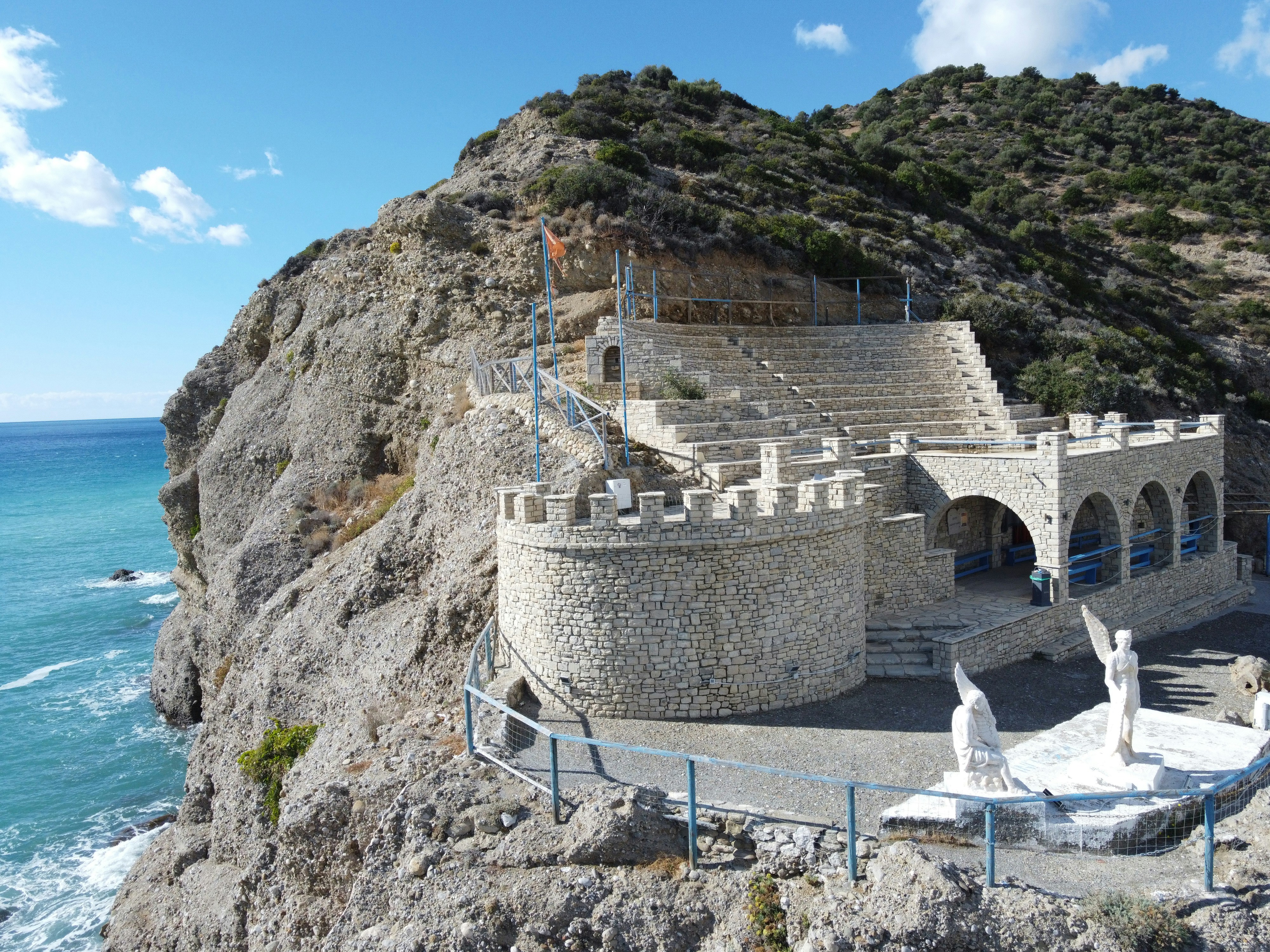 A large stone structure sitting on top of a cliff next to the ocean ...