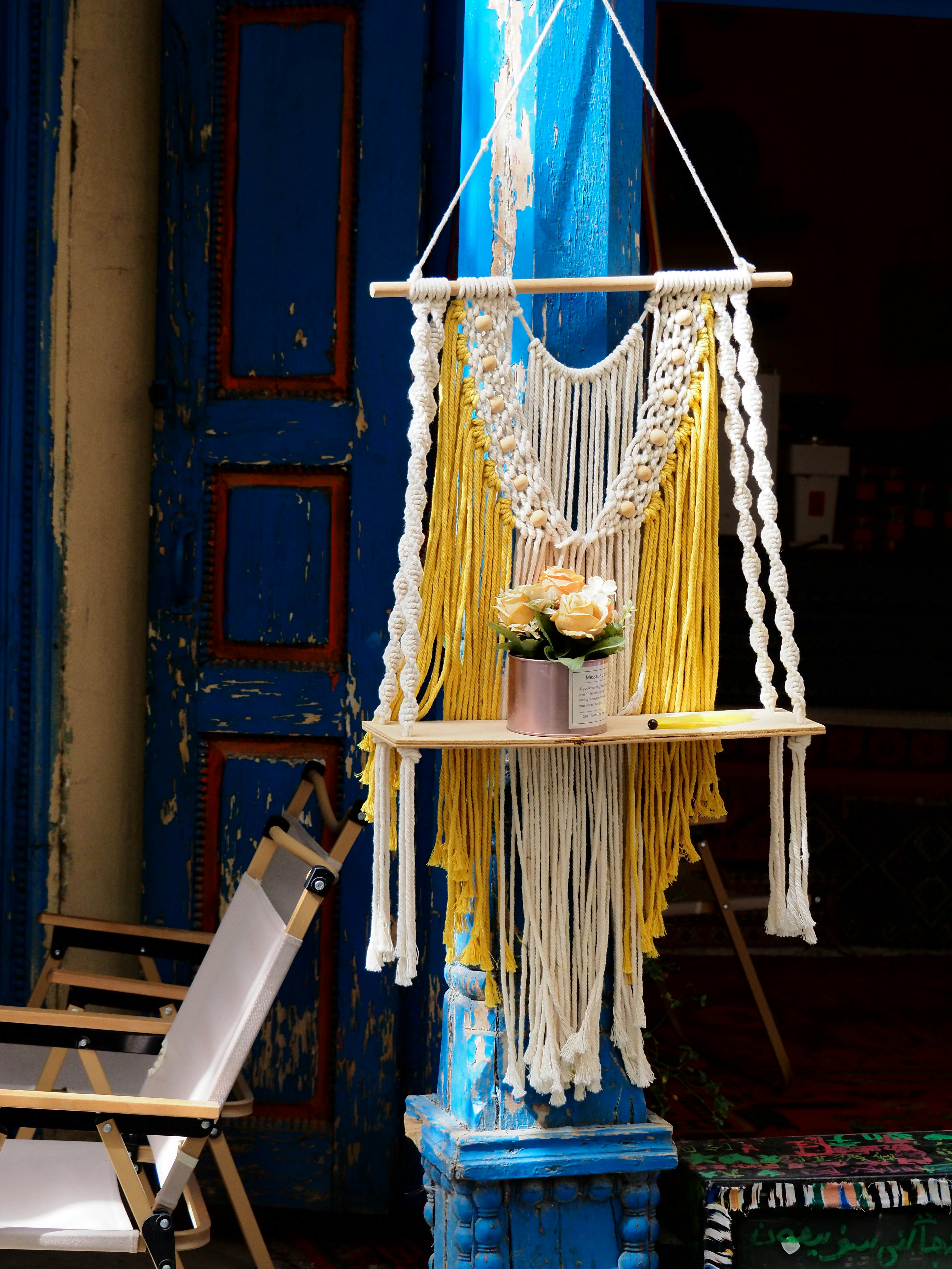 Macramé Swing Portrait: Yellow Threads, Pink Roses, and a Weathered Blue Door