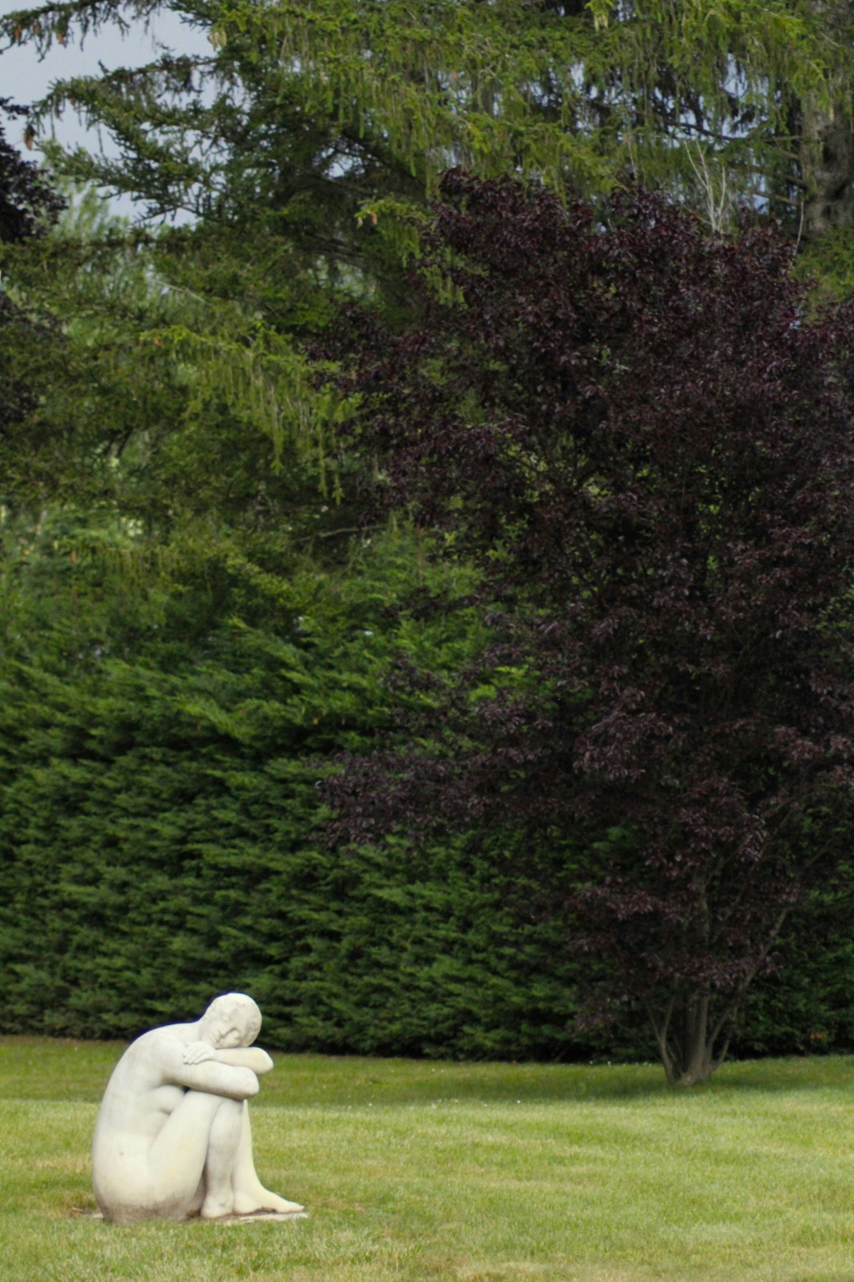 Stone Reclining: A Marble Figure at Rest Amid a Green Park
