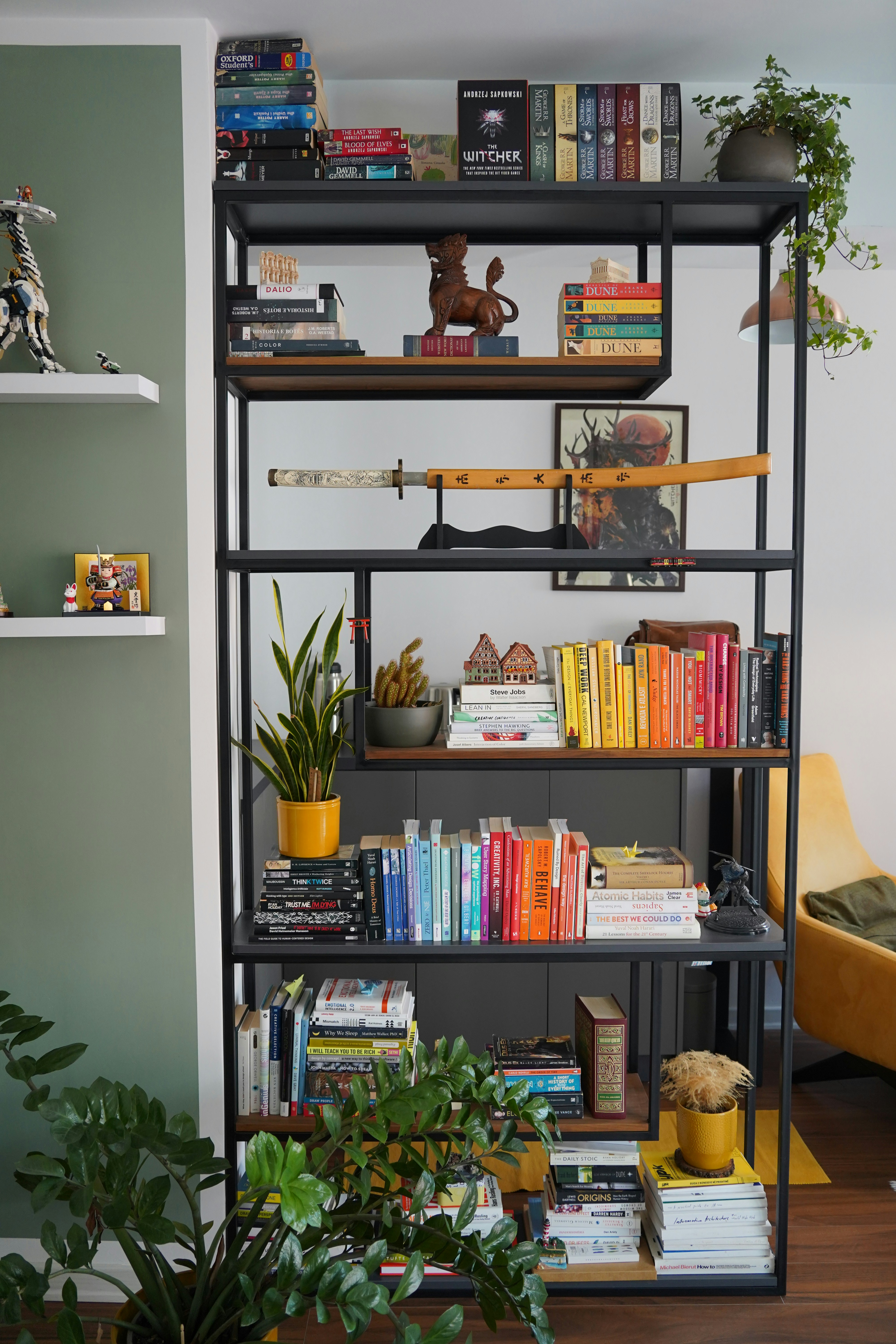 A bookshelf filled with lots of books next to a yellow chair photo ...
