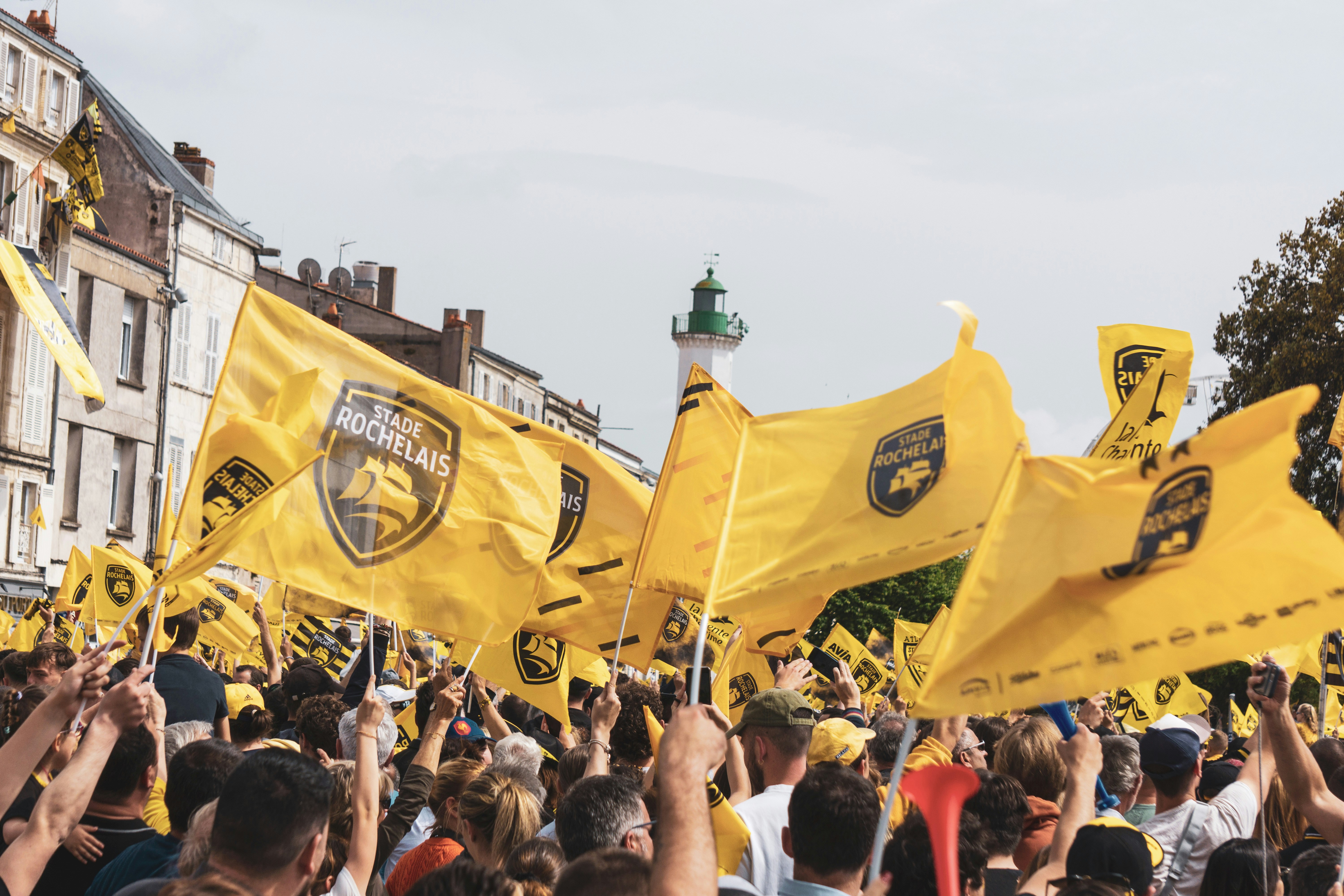 A crowd of people holding up yellow flags photo – Free People Image on ...