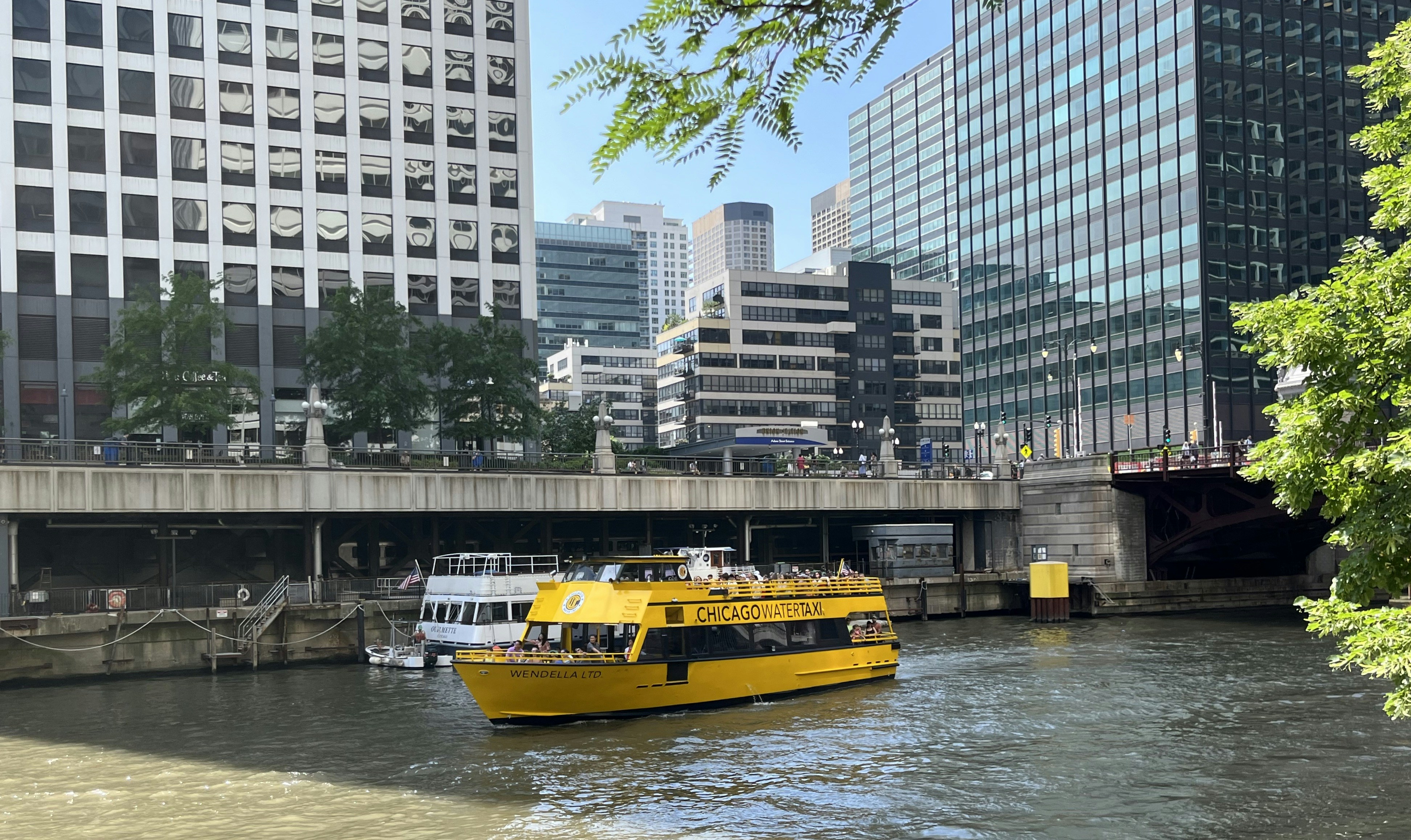 A yellow boat traveling down a river next to tall buildings photo ...