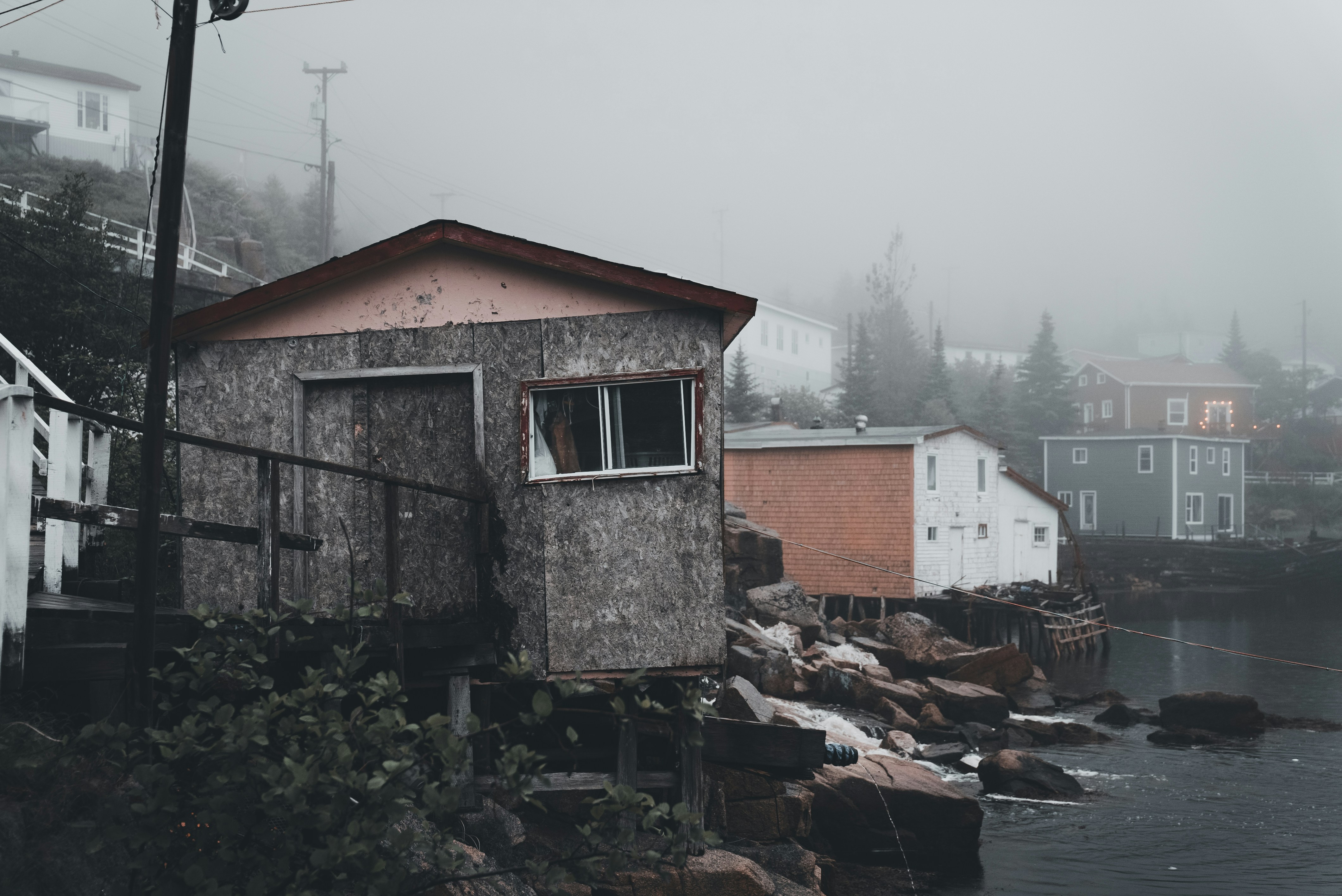 Fogbound Harbor Outpost: A Red-Roofed Beacon on the Rocks
