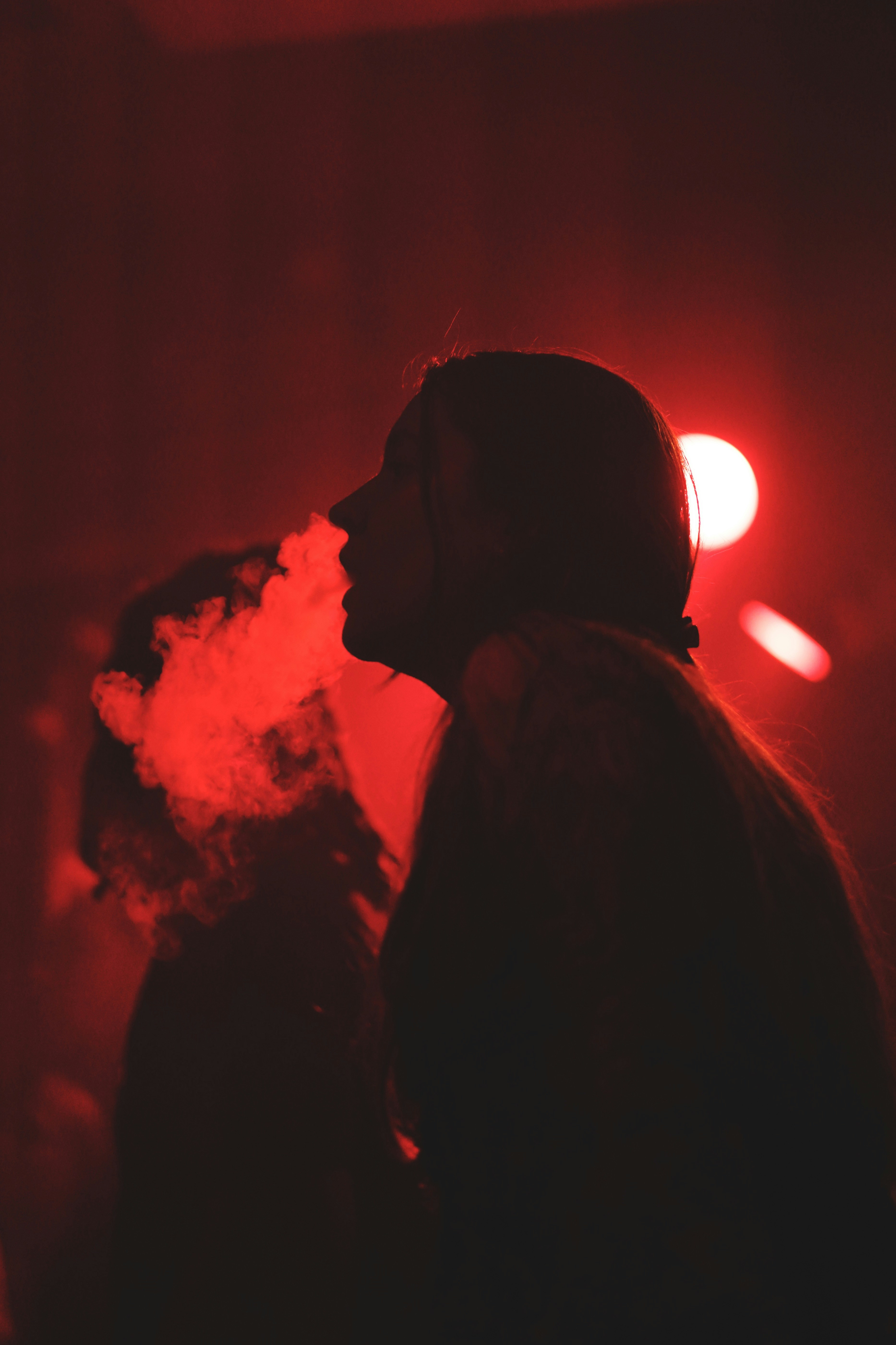 A person standing in front of a red light photo – Free Smoke Image on ...