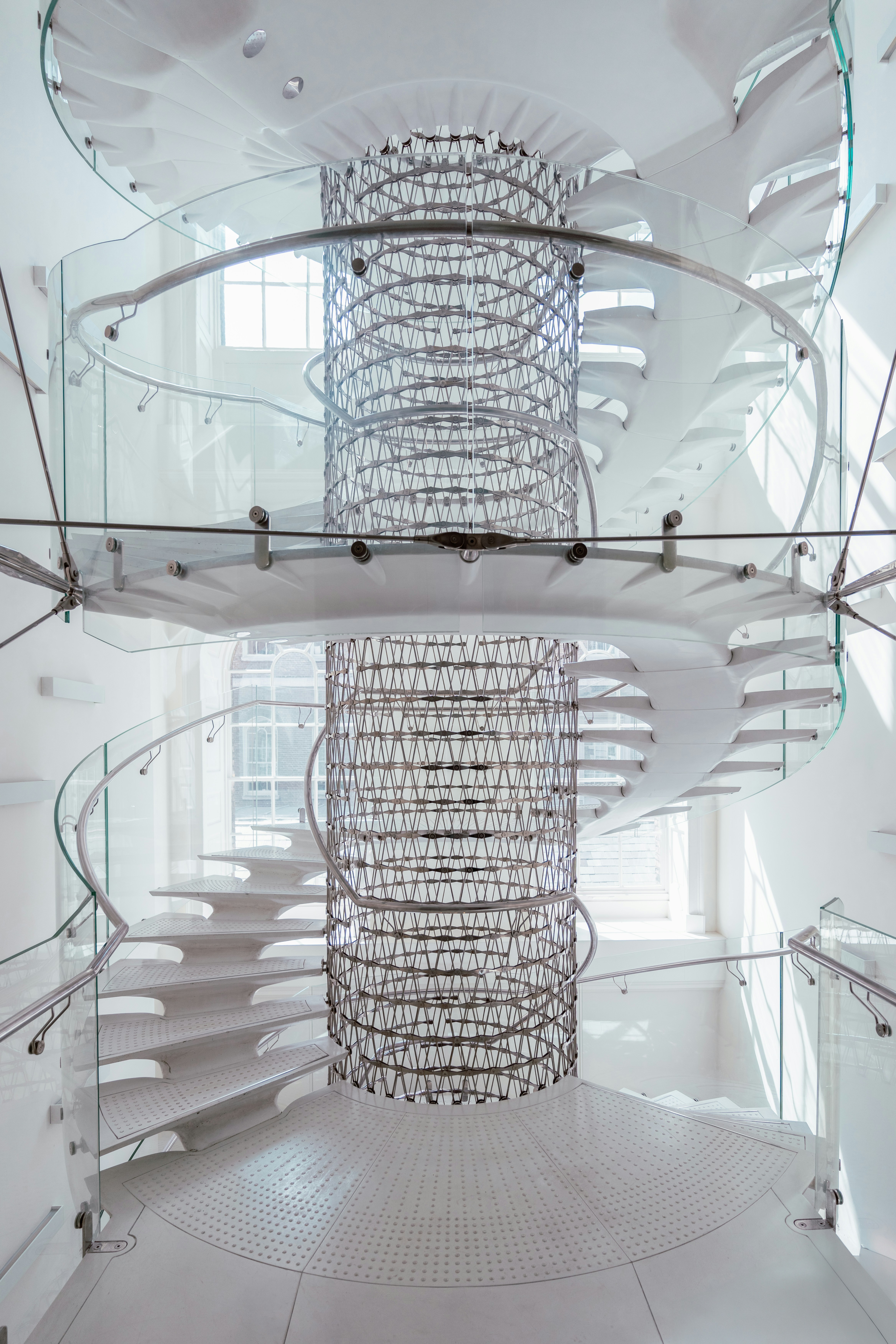 Lattice Helix Rising in a Glass-Rimmed Atrium