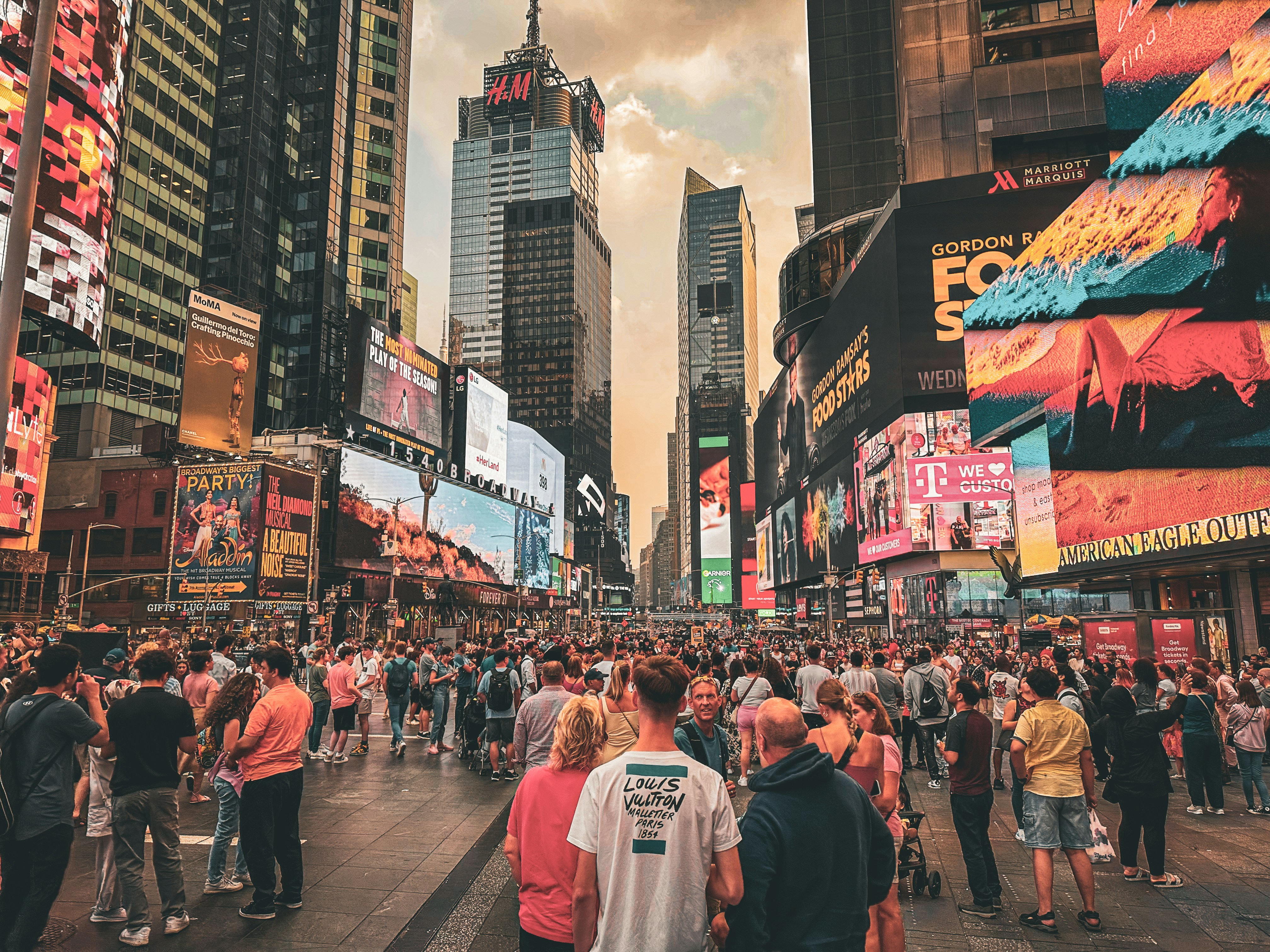 A crowd of people walking down a street next to tall buildings photo ...