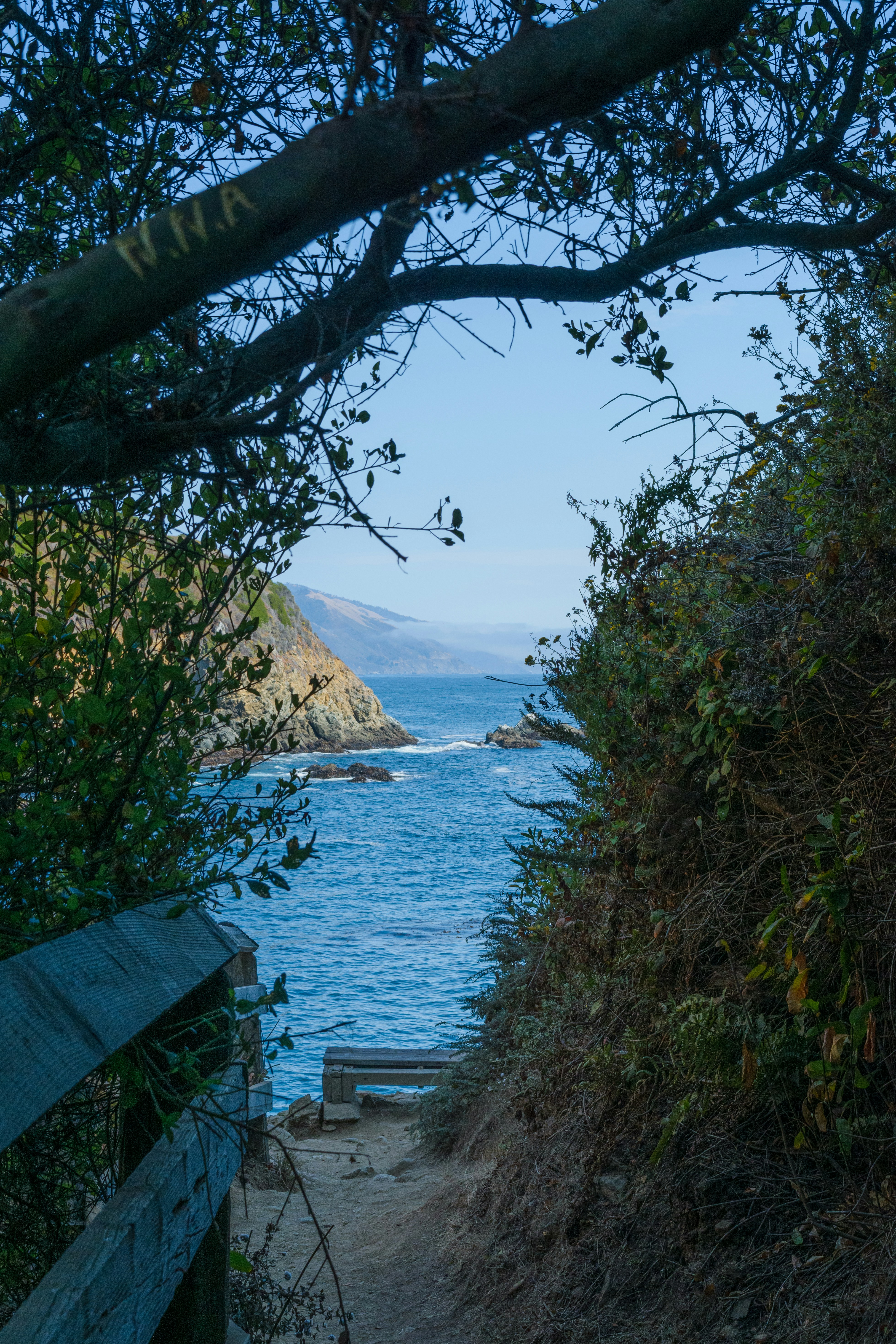 Framed Descent to the Sea: A Narrow Corridor Opening onto Blue Horizons