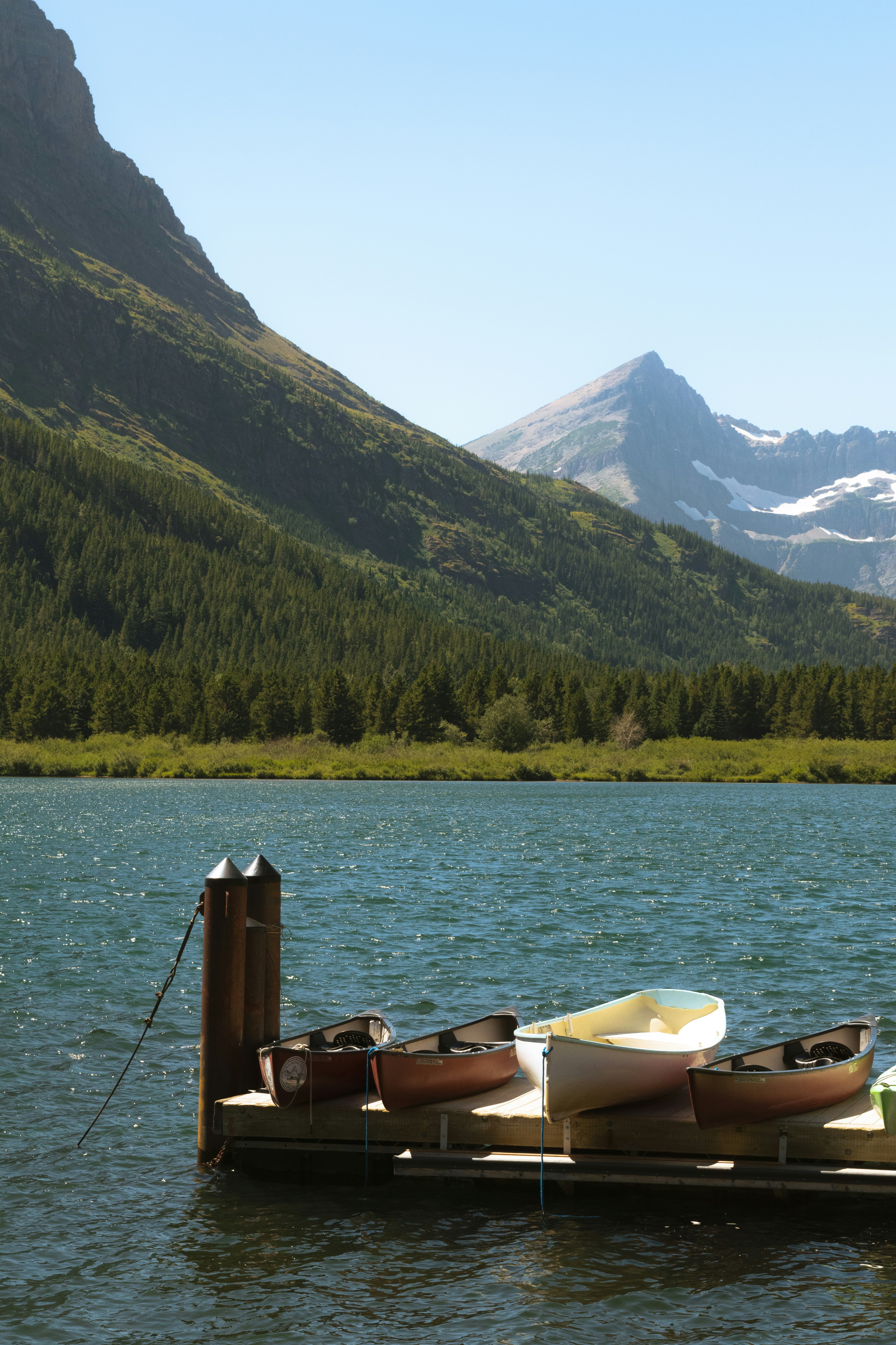 Boats at a Mountain Lake Dock Under a Clear Alpine Sky