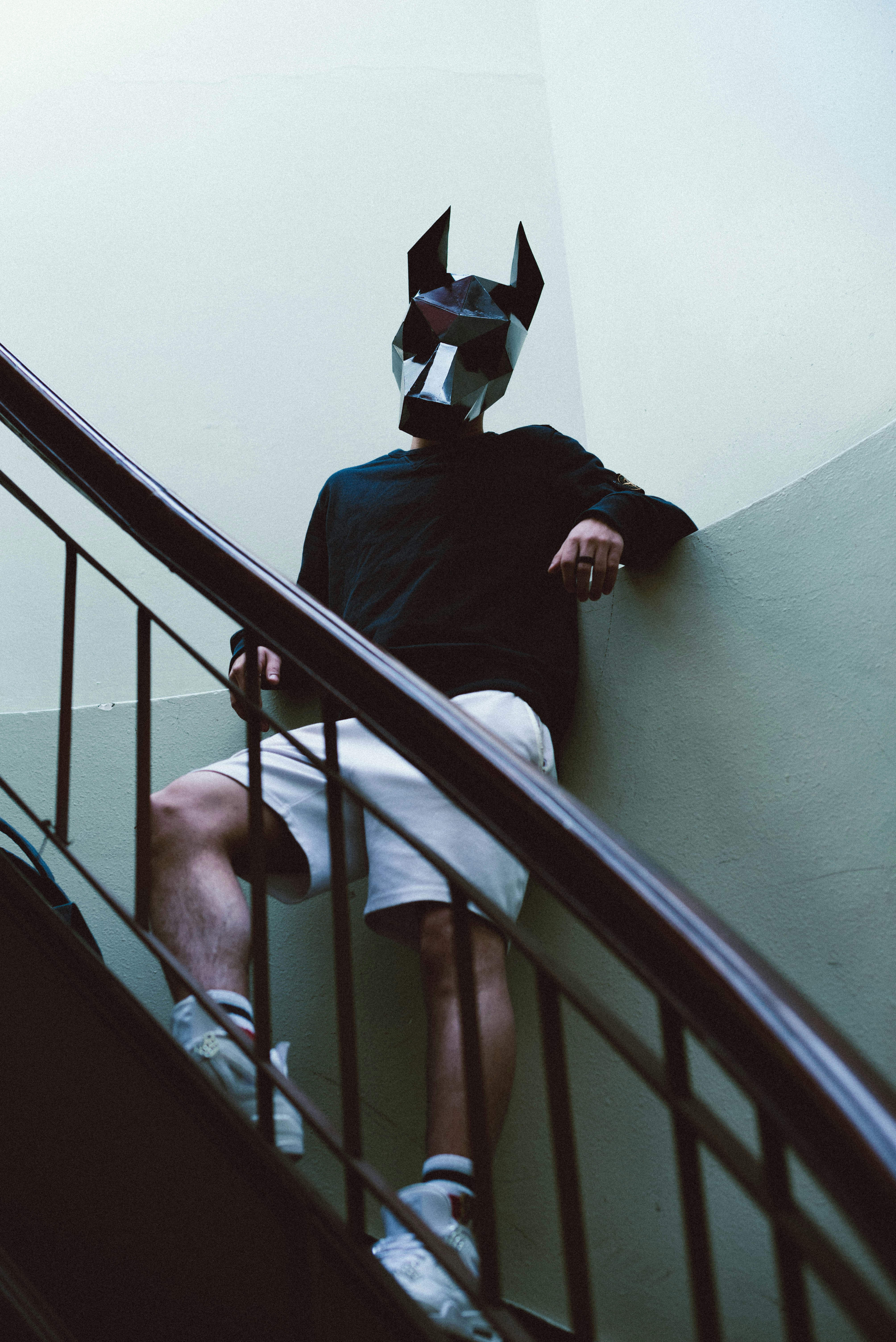 Masked Descent: Batman-Inspired Figure on a Winding Stair