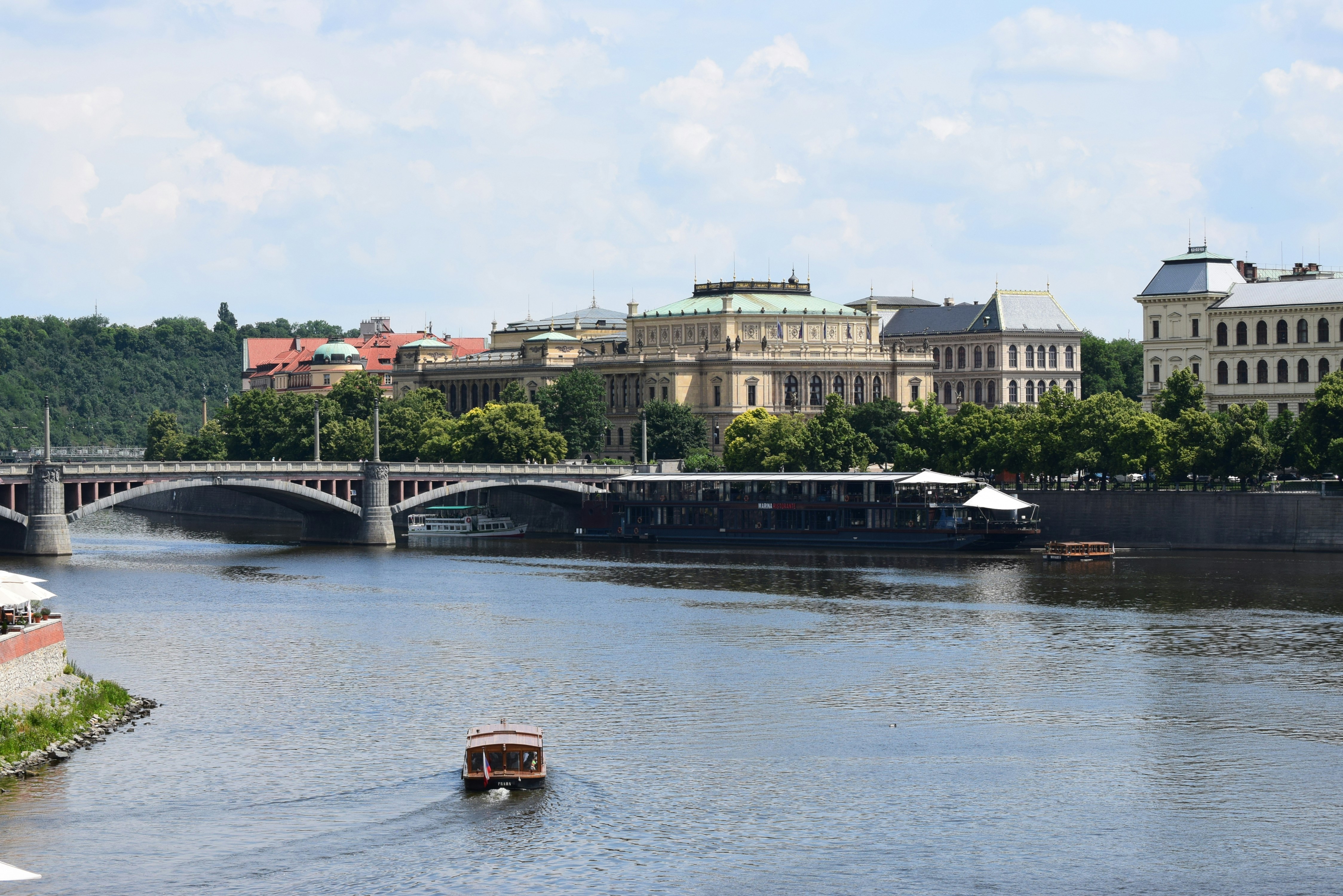 a boat traveling down a river next to a bridge