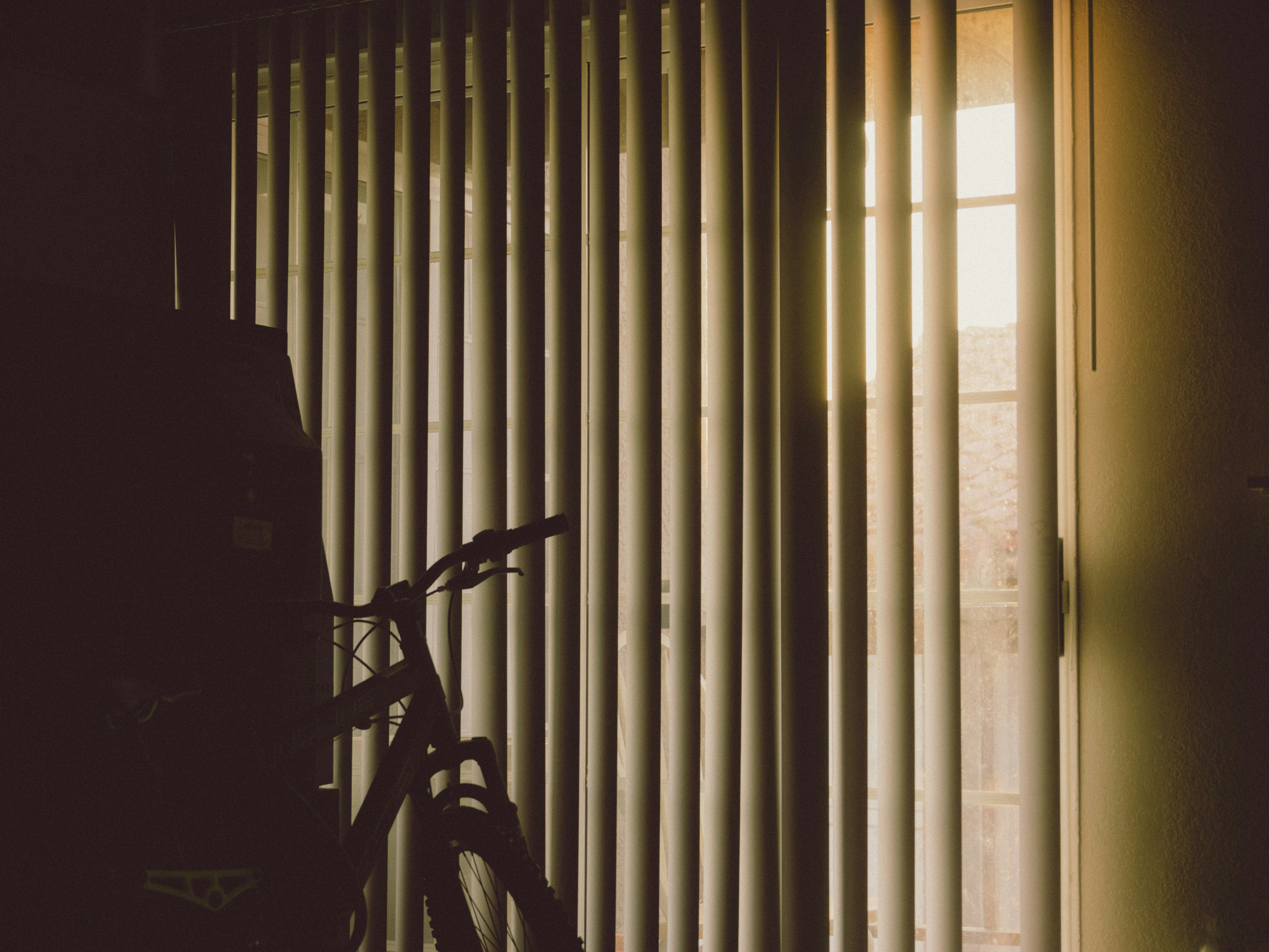 Glimmer Between Slats: A Backlit Moment by the Quiet Window