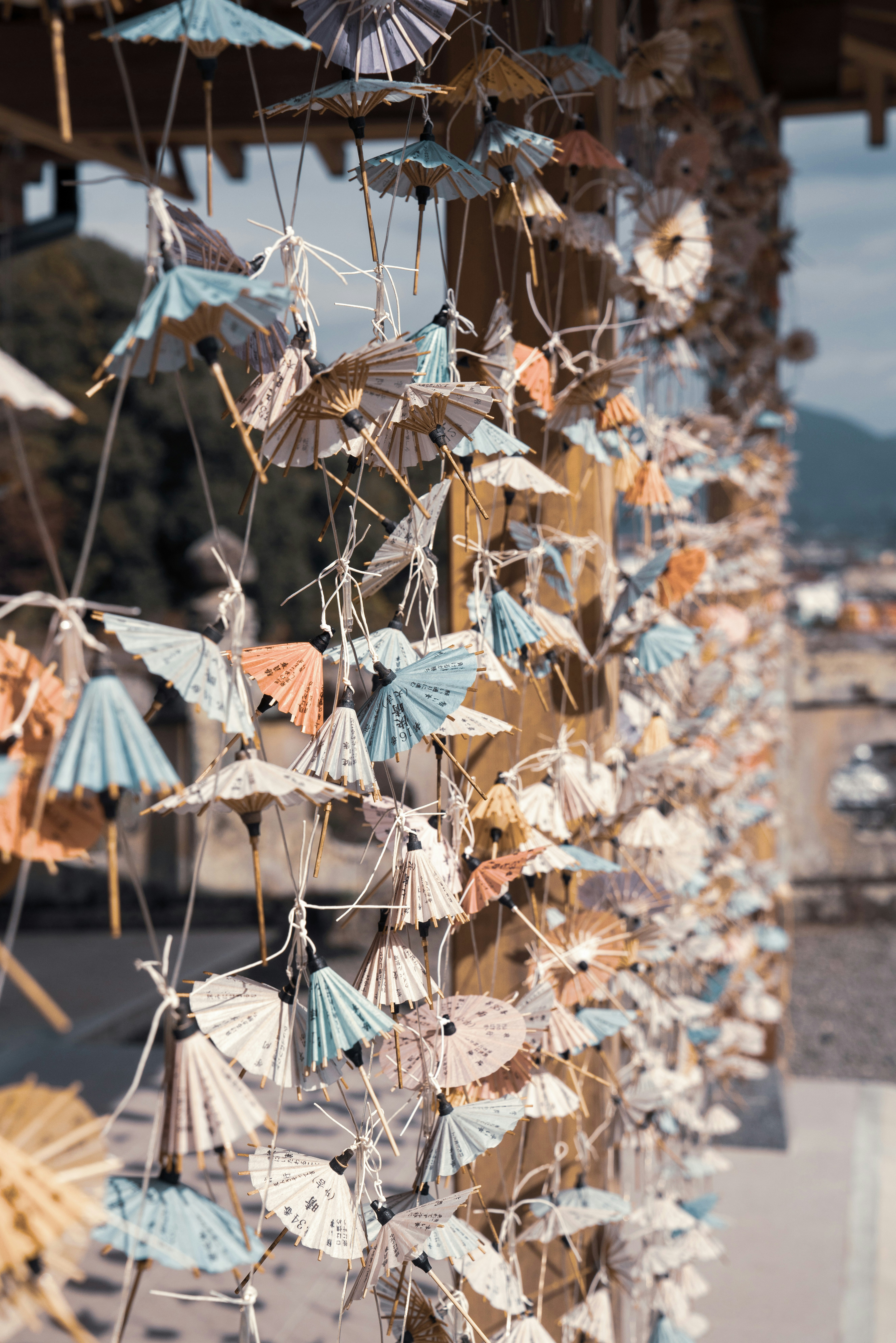 A bunch of paper umbrellas hanging from a pole photo – Free Japan Image ...