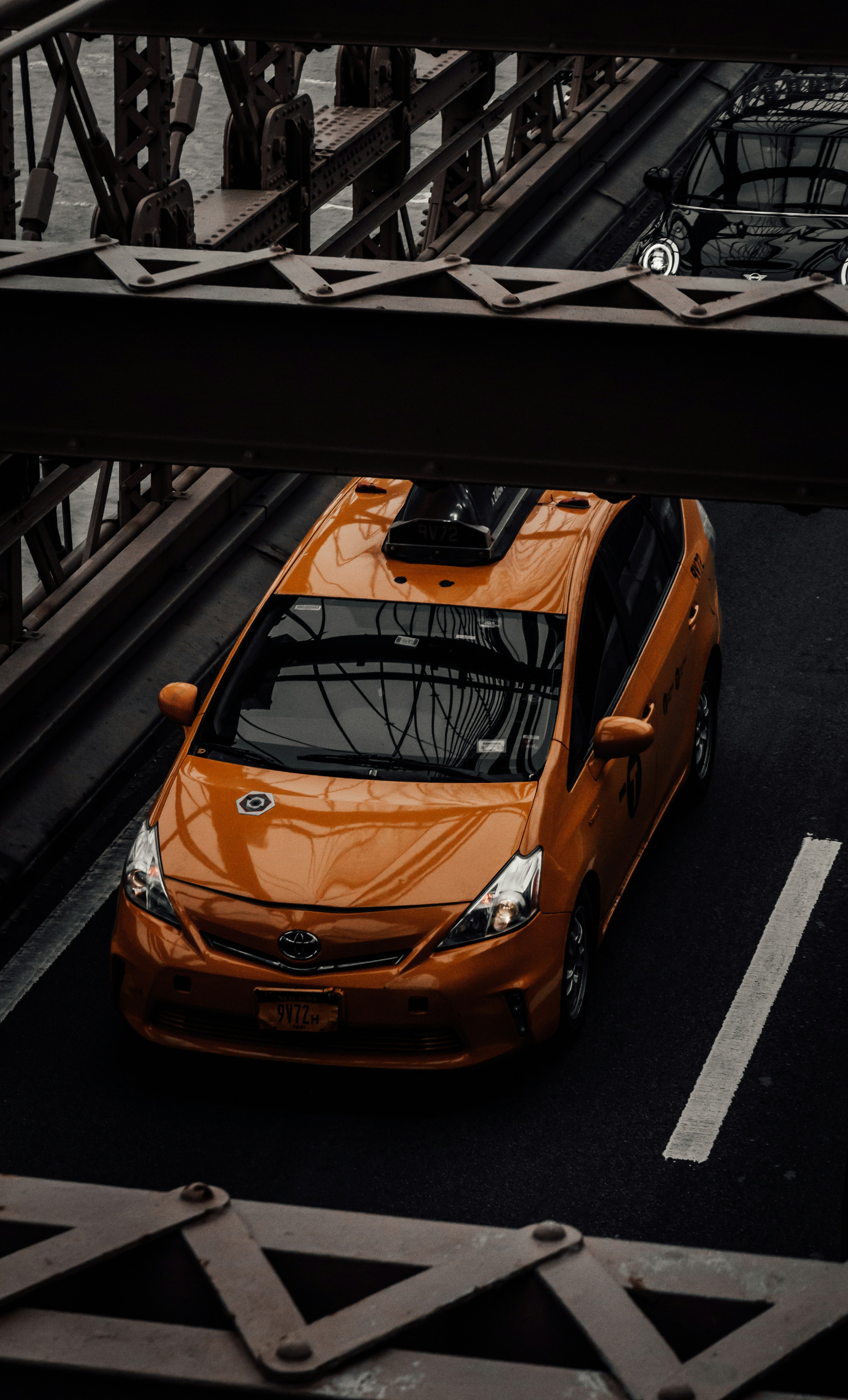 Orange cab under steel桥: a rooftop perspective over traffic