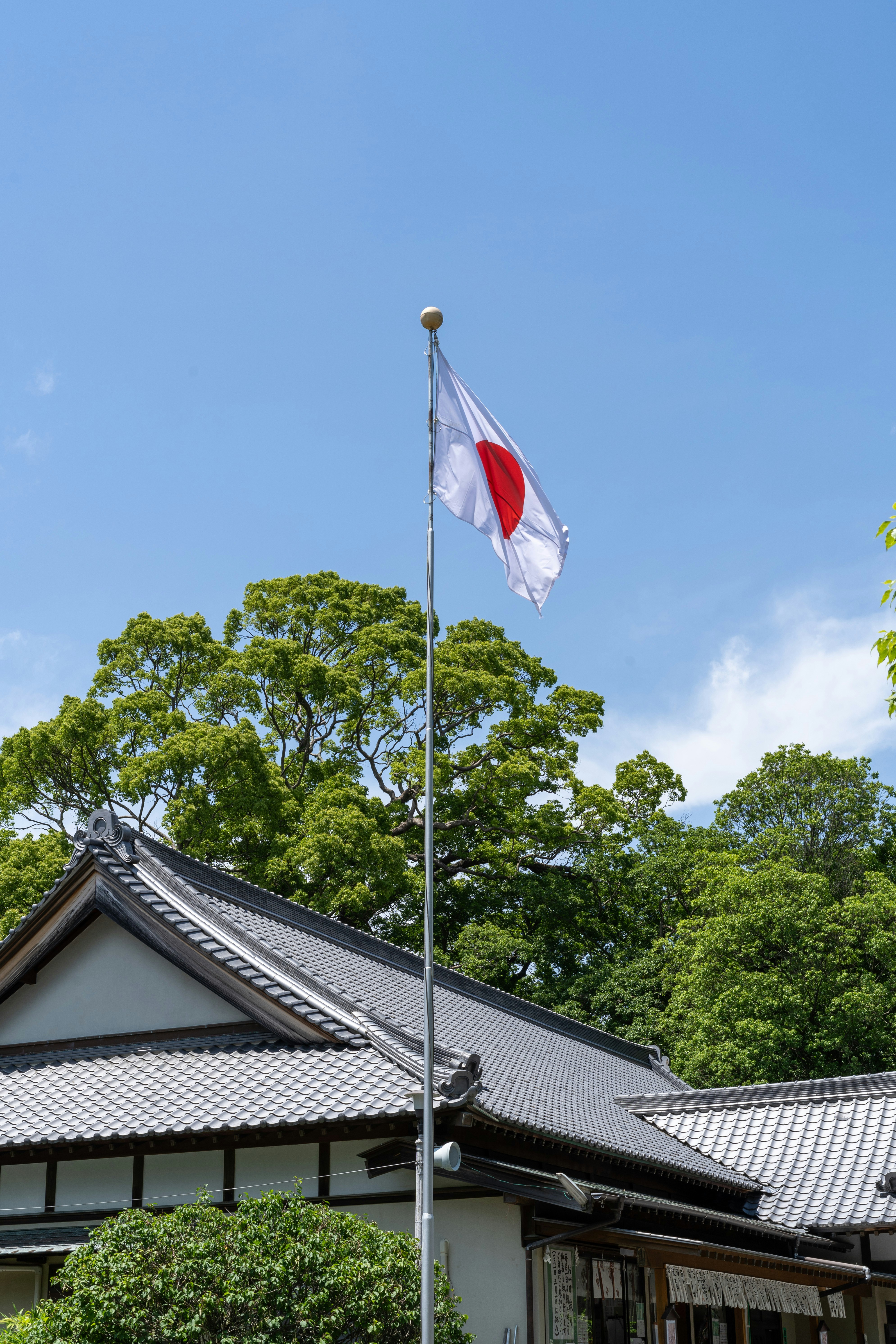 Flag Above the Eaves: A Quiet Portrait of Tradition Under a Blue Sky