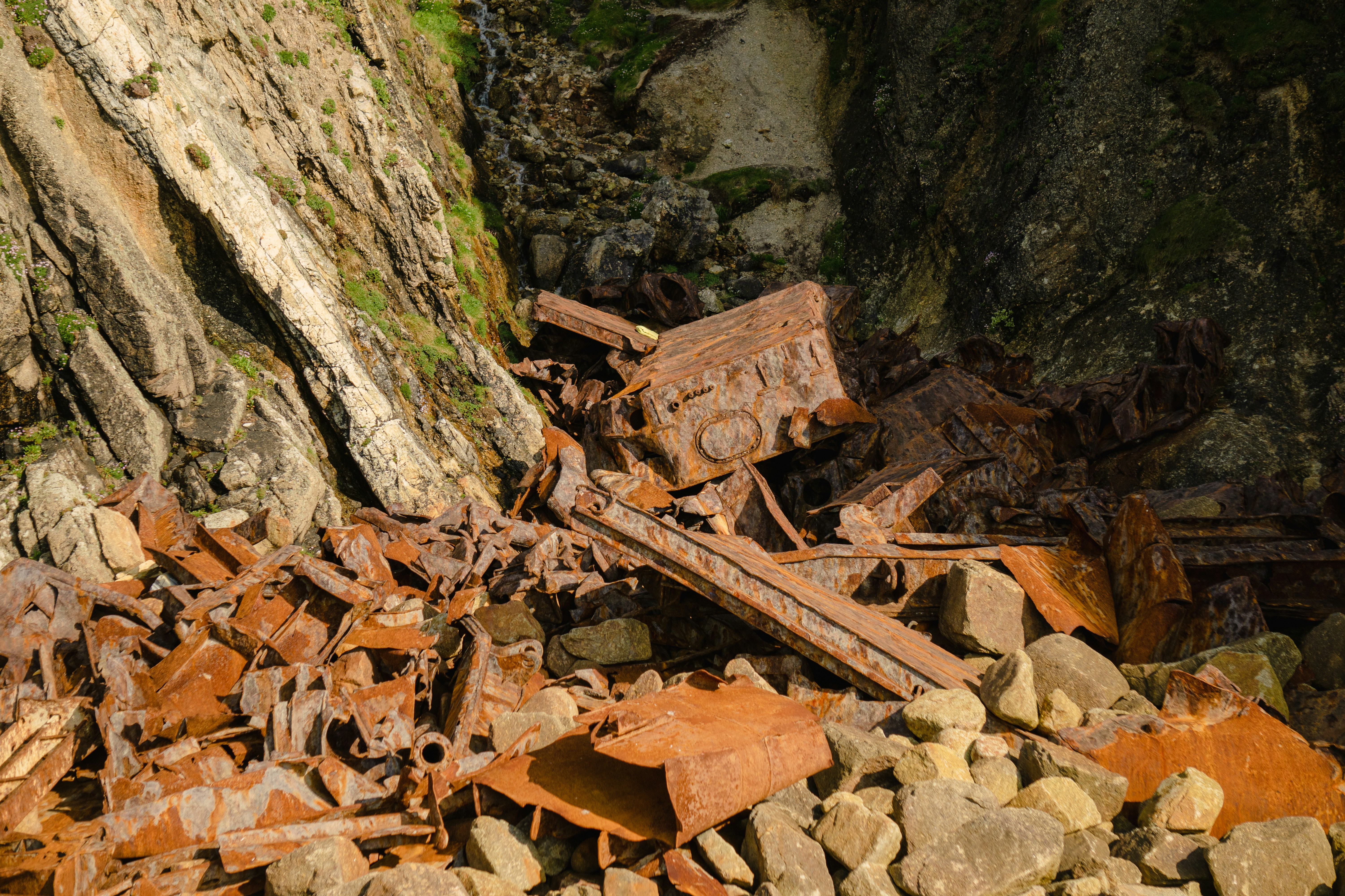 Rust Relics at the Edge of a Sunlit Rock Crevice