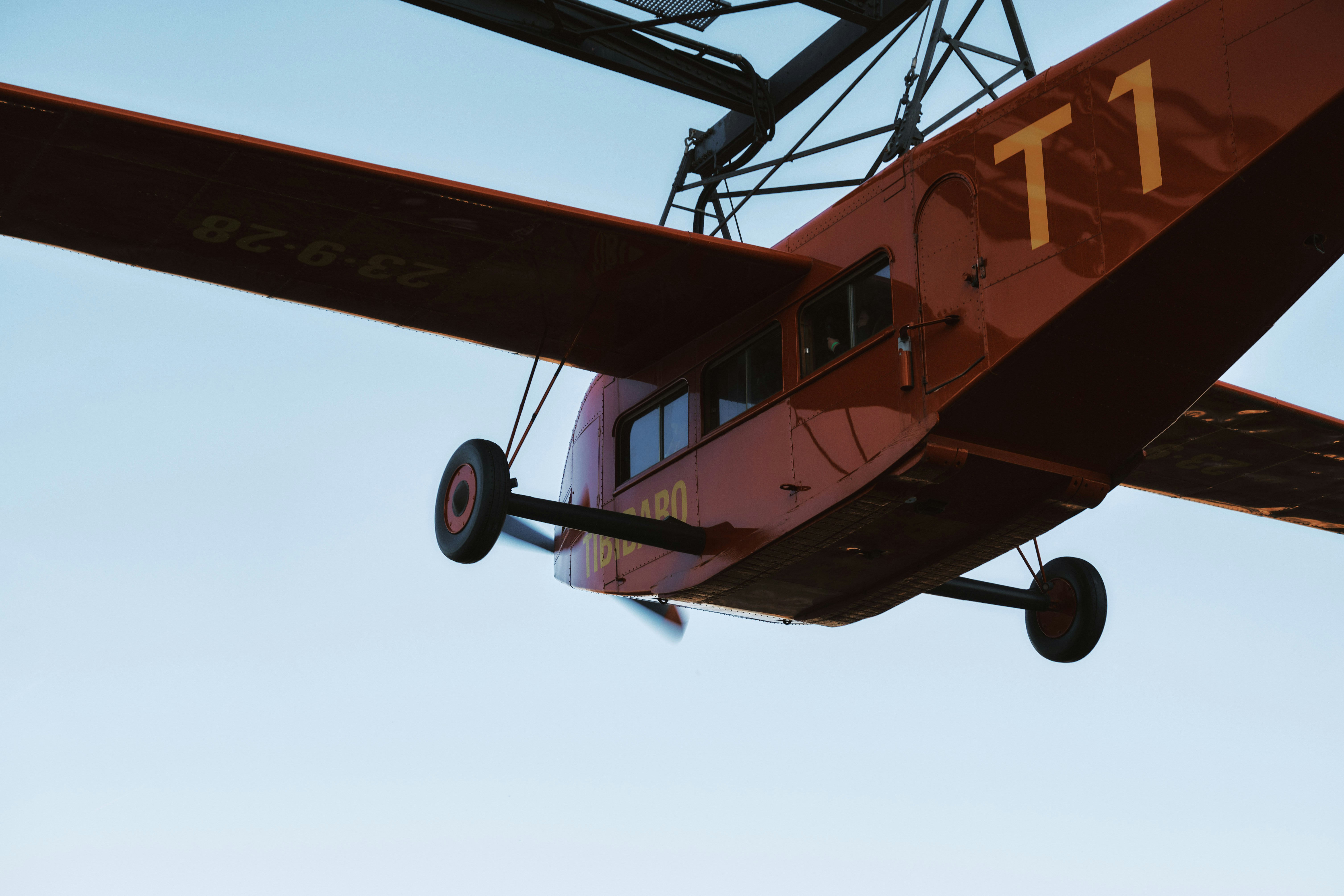 A small red airplane flying through a blue sky photo – Free Barcelona ...