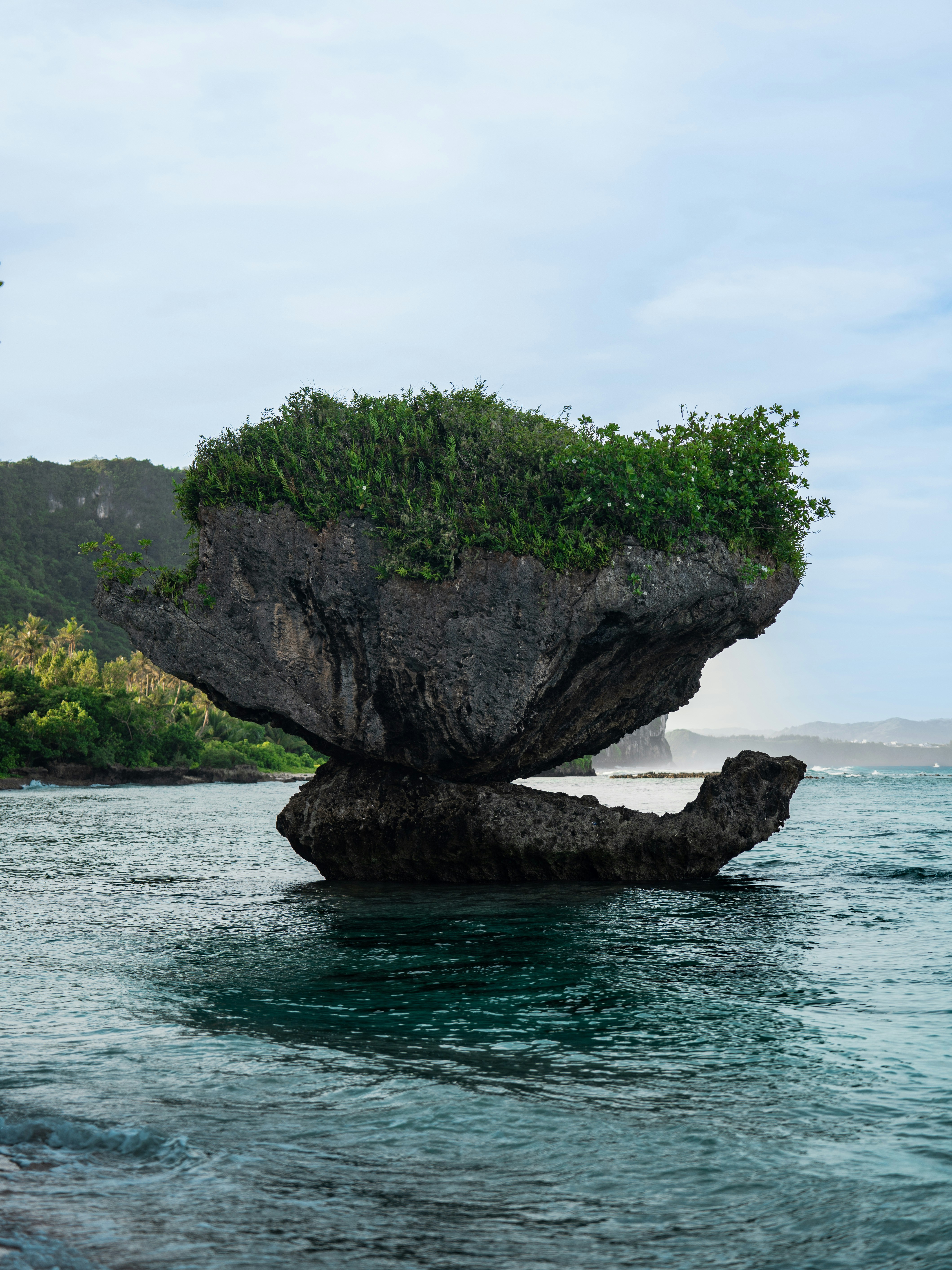 A rock formation in the middle of a body of water photo – Free Guam ...