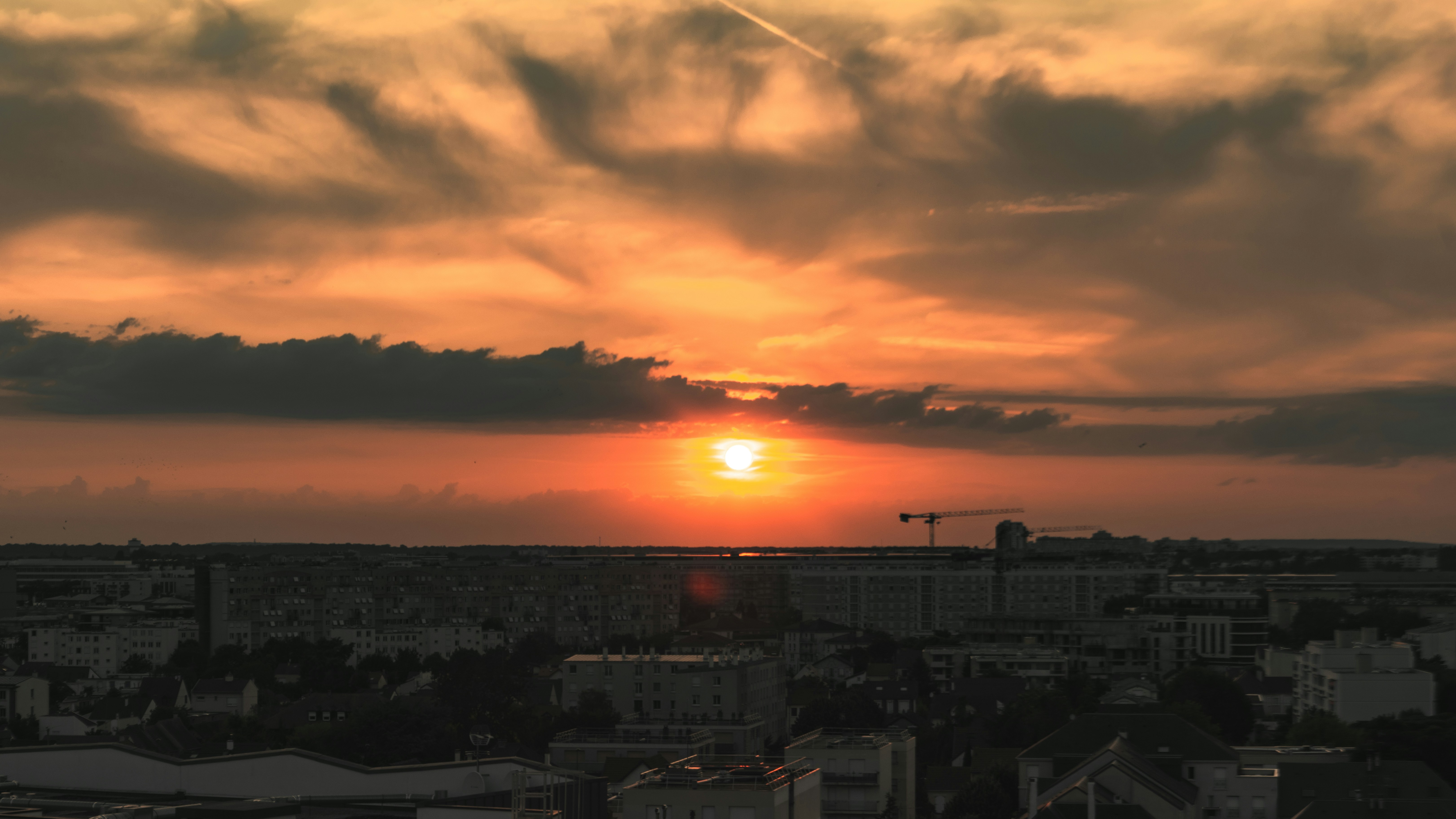 The sun is setting over a city with tall buildings photo – Free Rueil ...