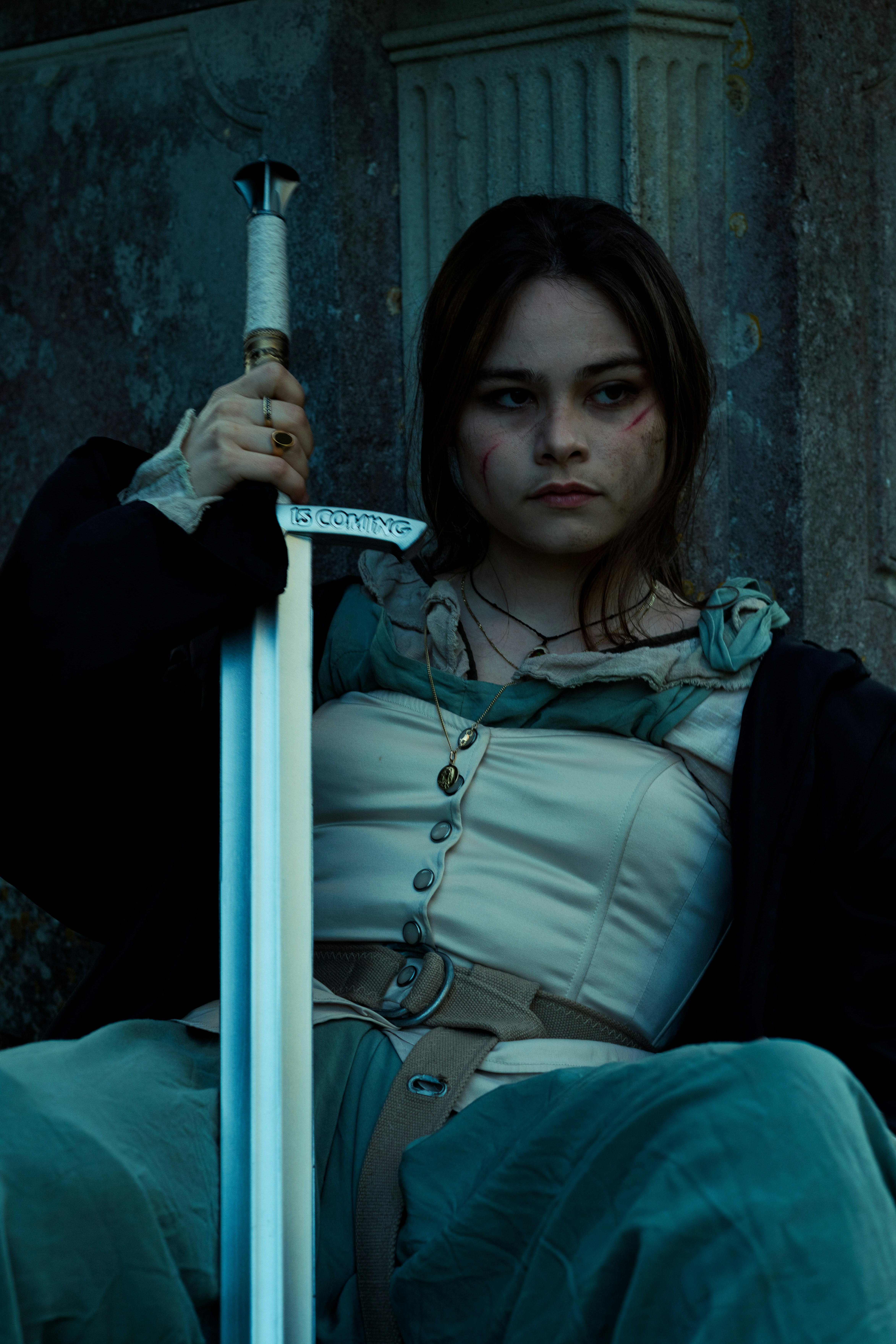 A woman sitting on a chair holding a sword photo – Free Sword Image on ...