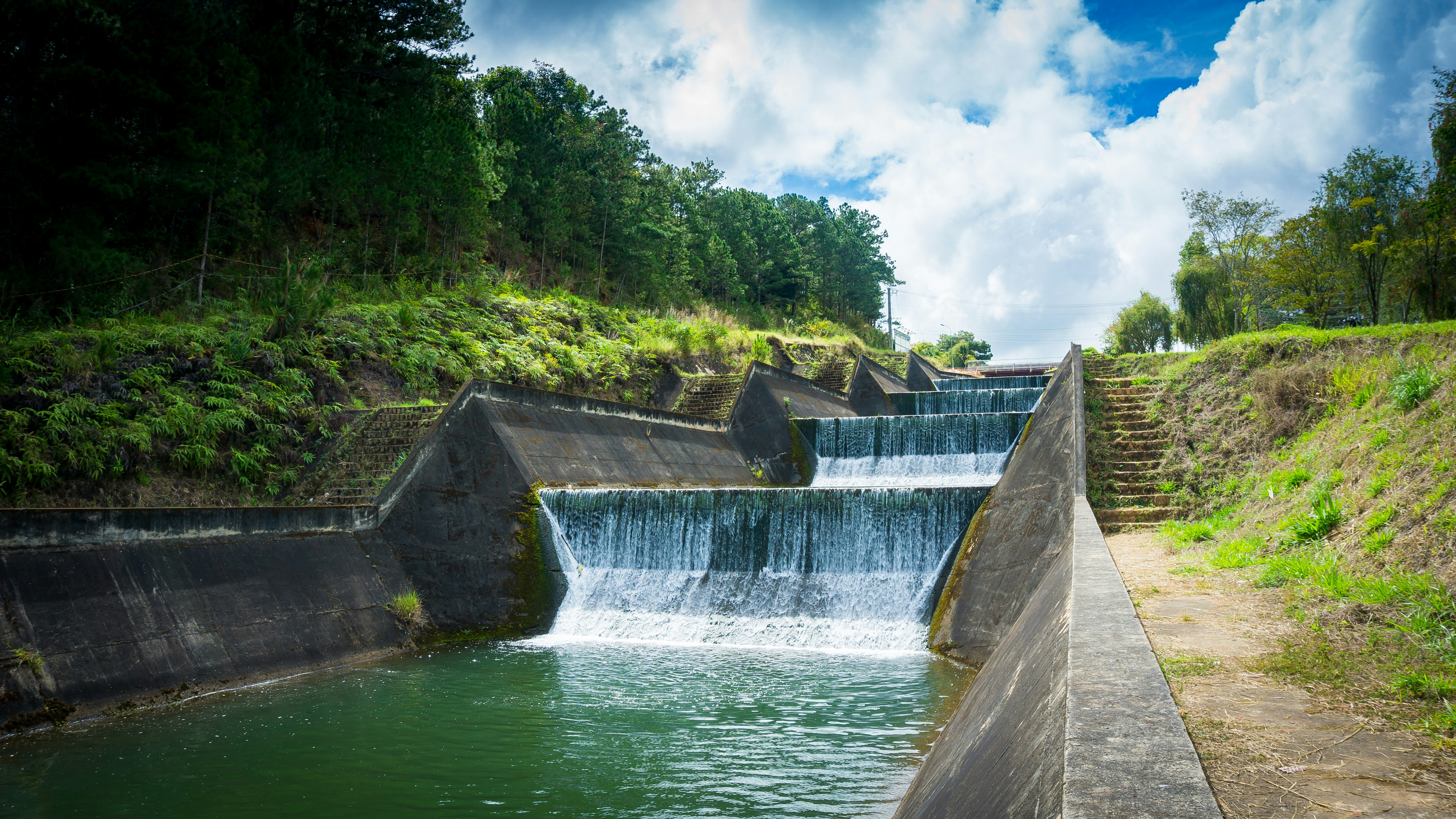 A dam with water running down it and a bunch of steps leading up to it ...