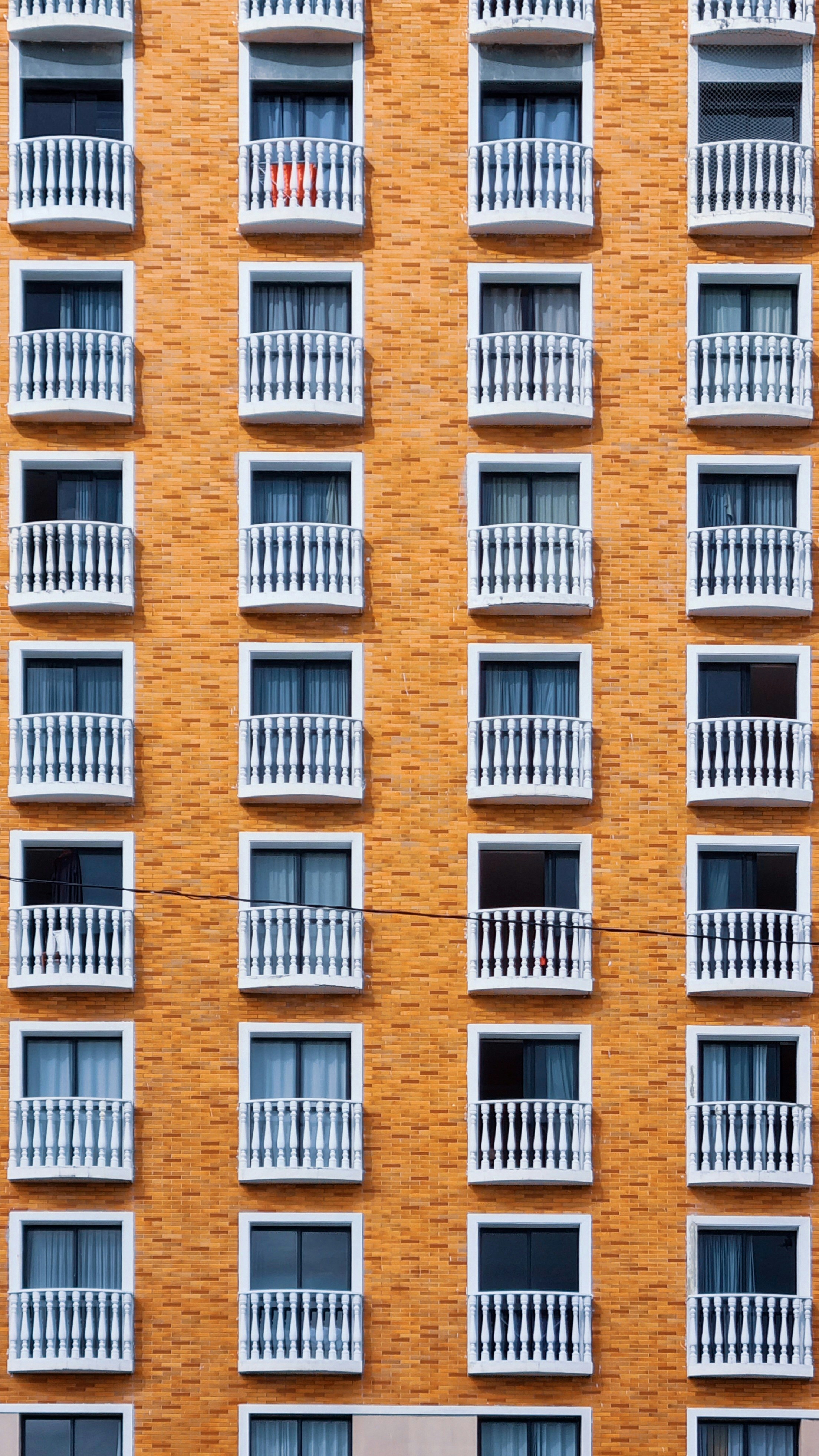A tall brick building with balconies and balconies photo – Free ...