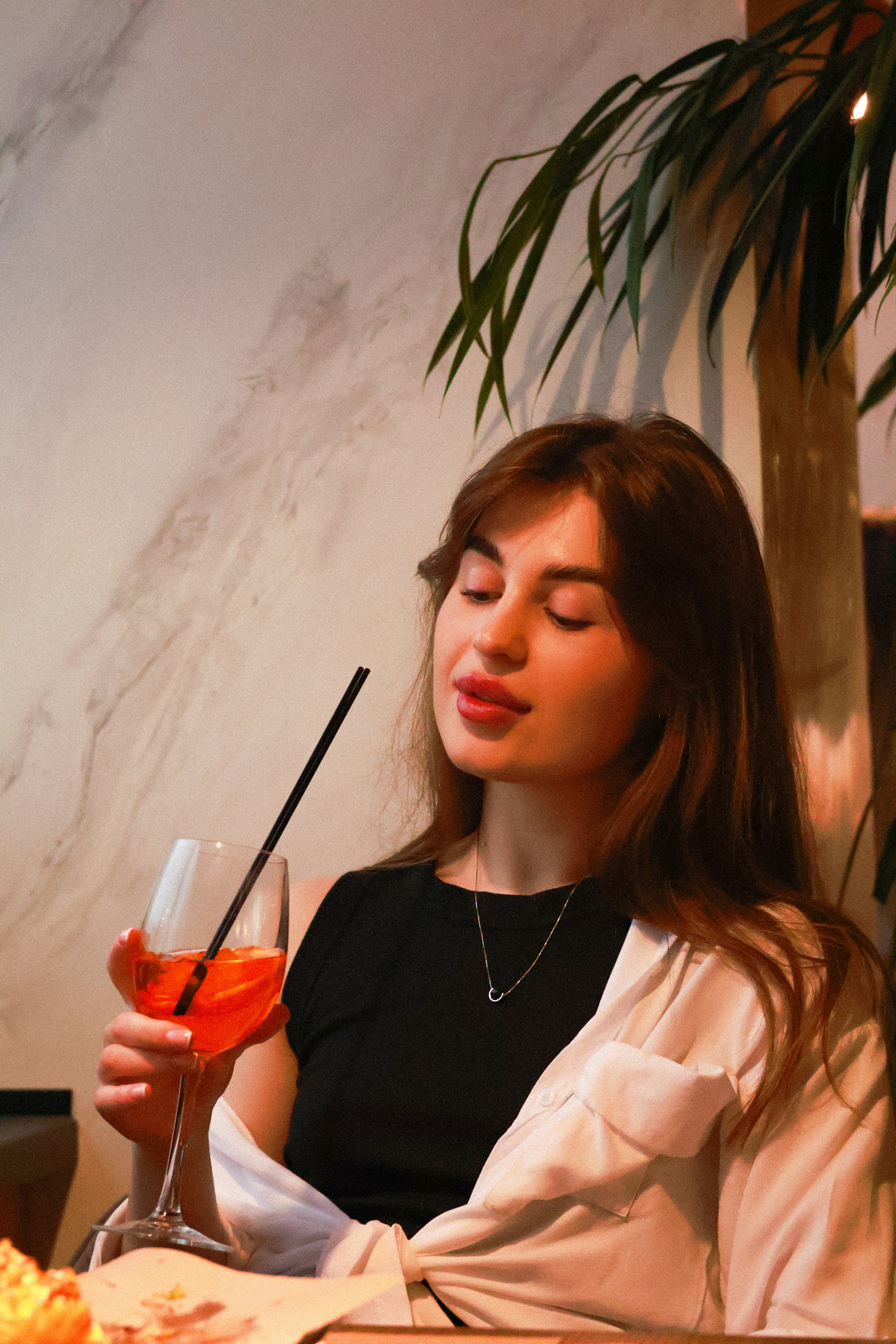 Crimson Glass, Quiet Glow: A Velvet-lit Portrait in a Lounge