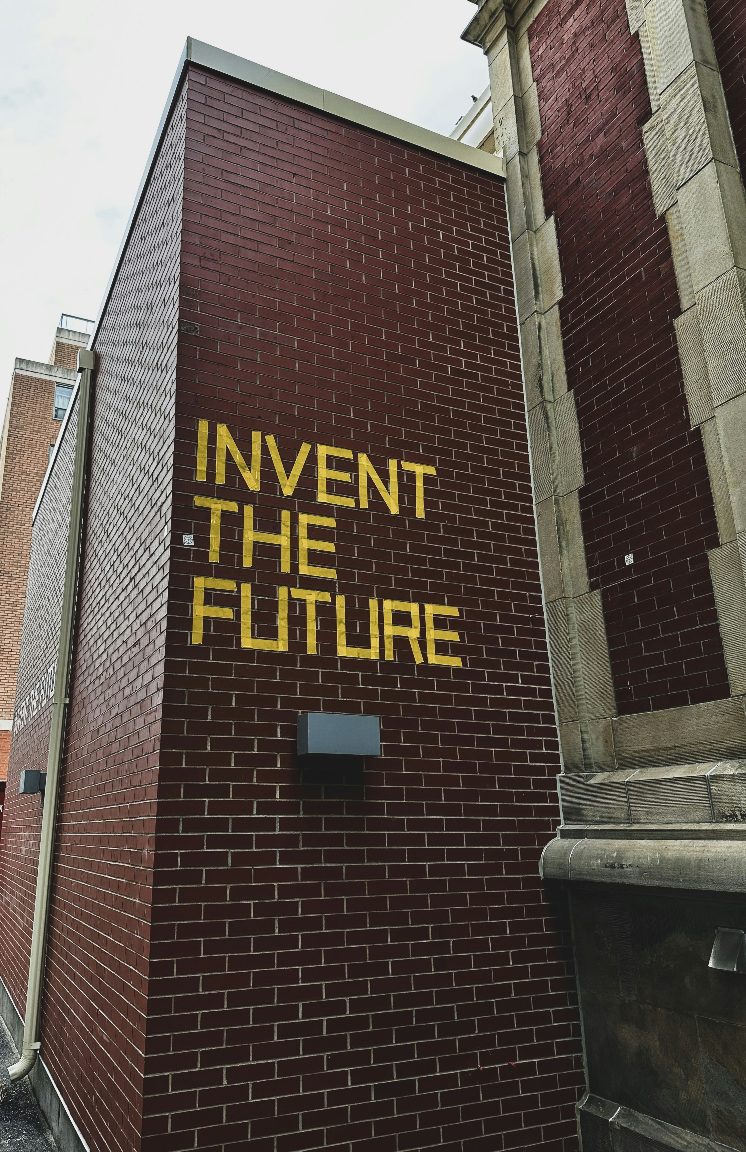 A brick building with a sign that says invent the future photo – Free ...
