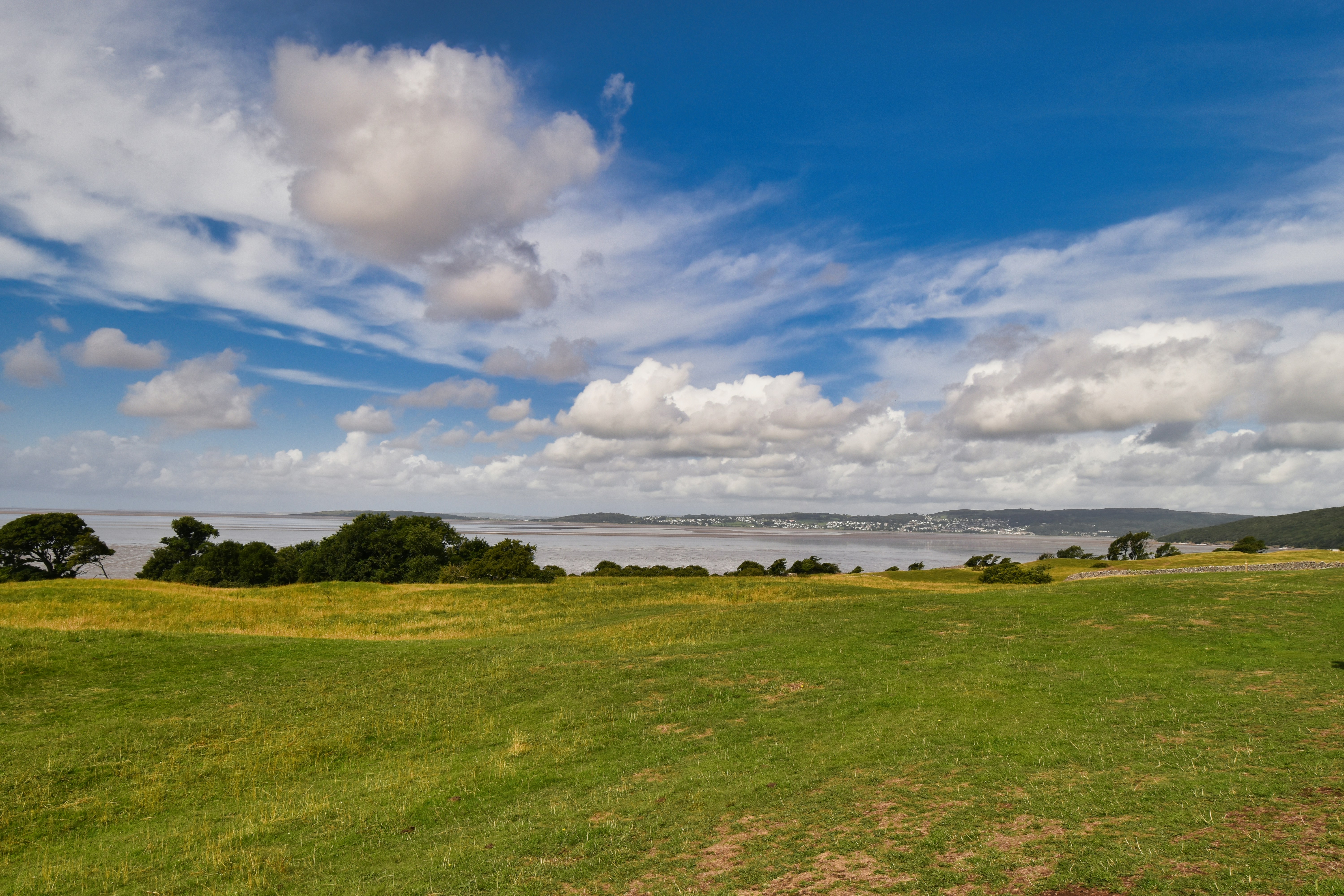 A grassy field with a lake in the distance photo – Free Uk Image on ...