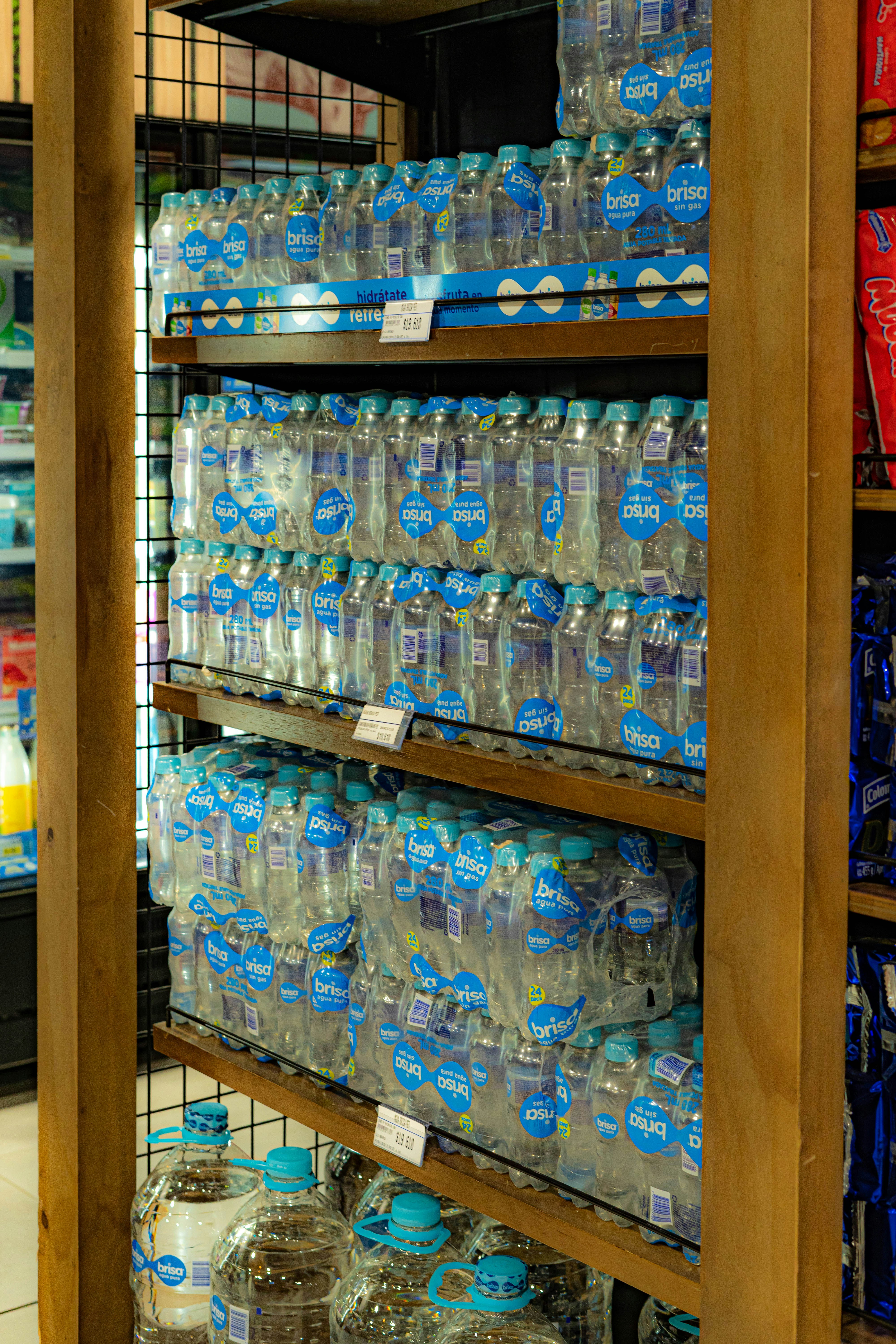 A large display of bottled water in a store photo – Free Shelf Image on ...