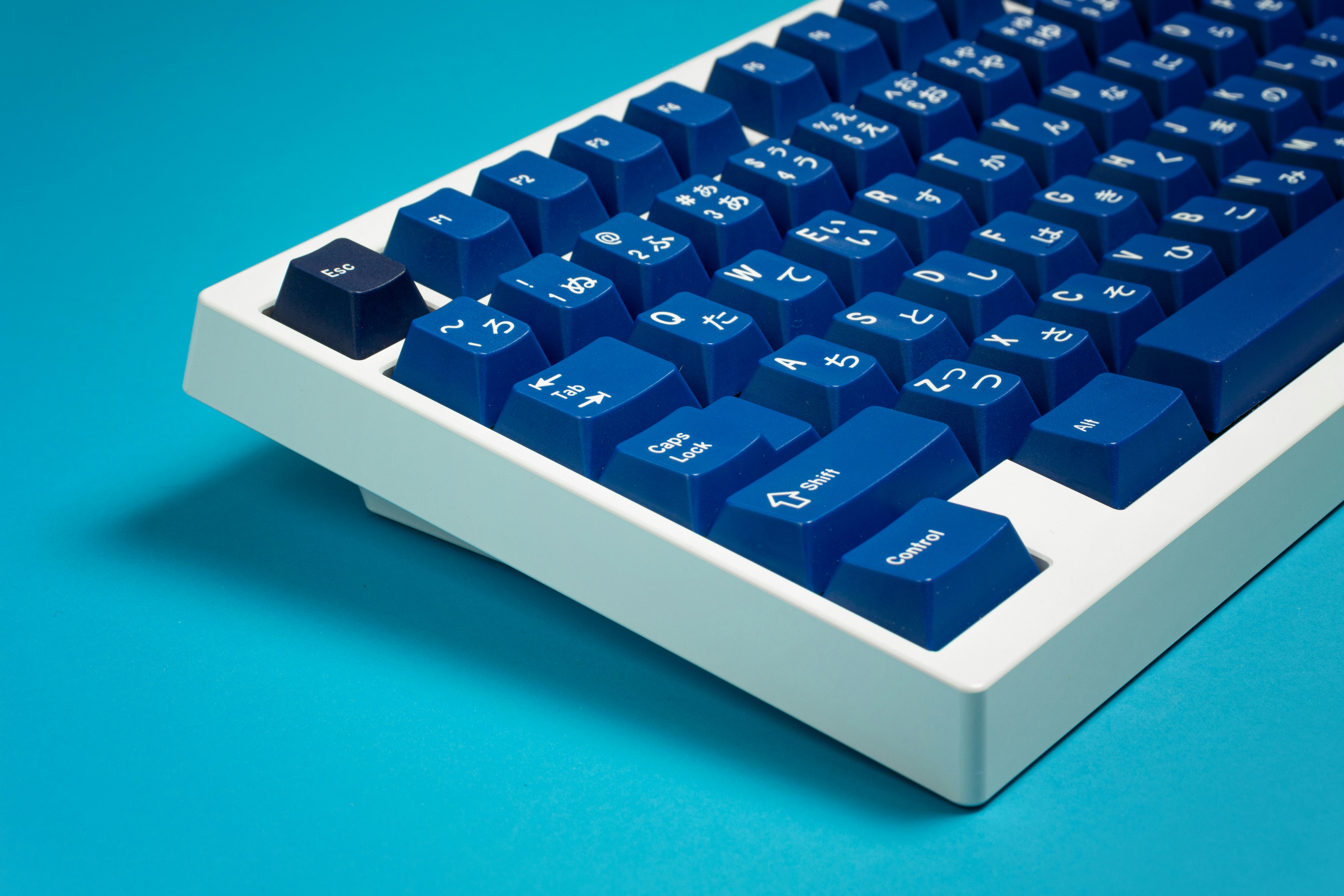 A blue and white computer keyboard on a blue surface photo – Free ...