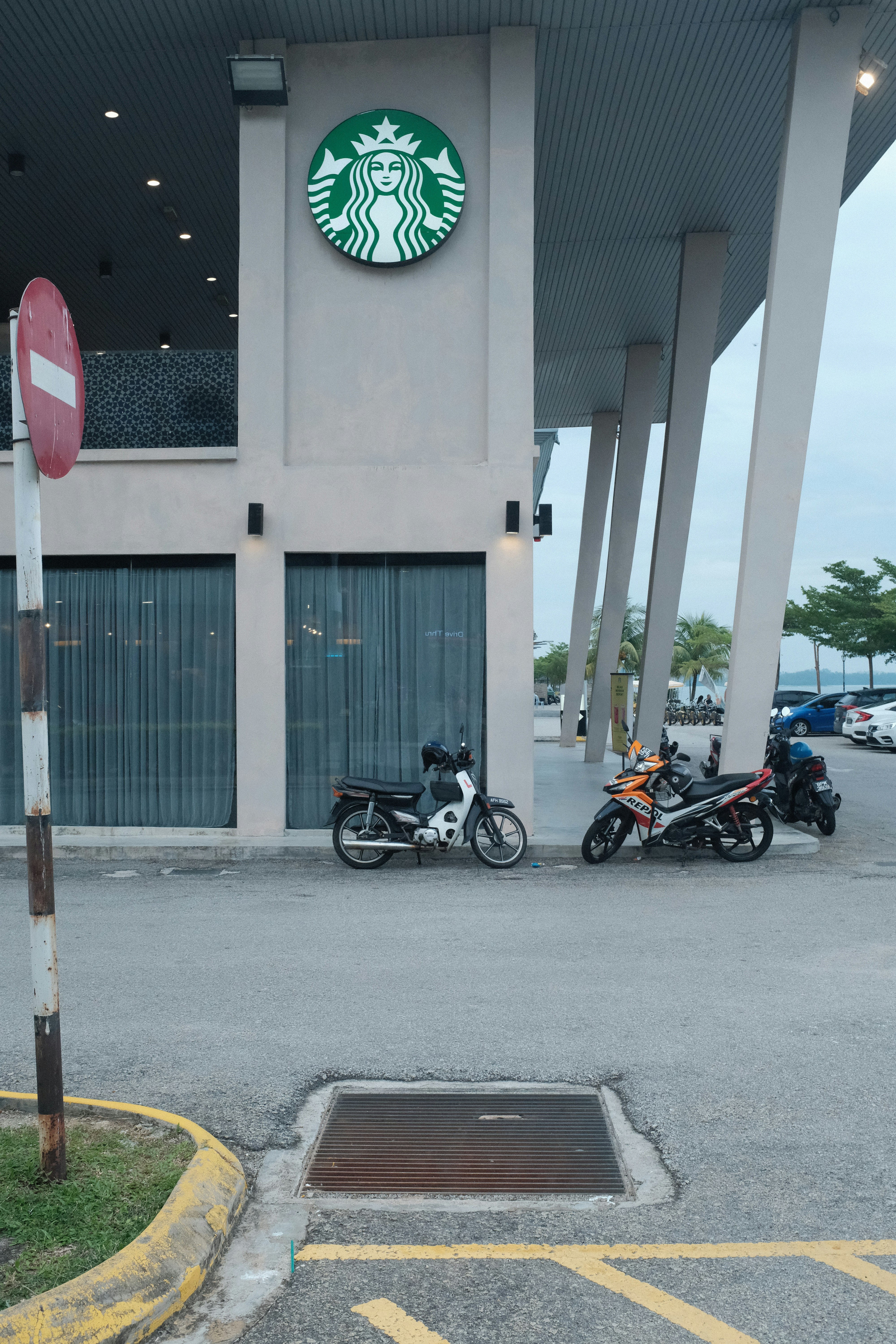 Green Circle, Concrete Angles: Starbucks Facade Framed by Motorcycles