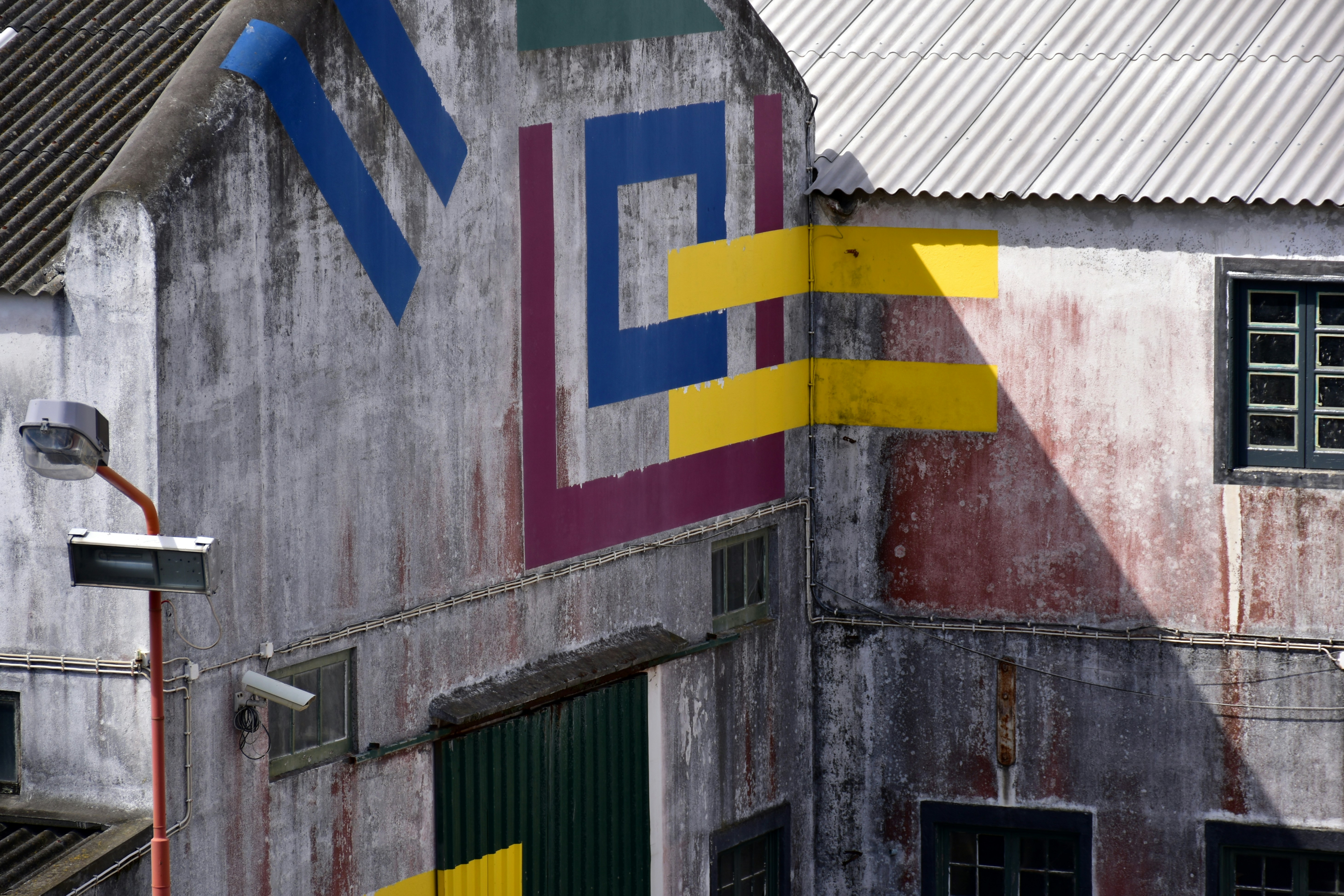 Chromatic Geometry Clings to a Weathered Warehouse Wall