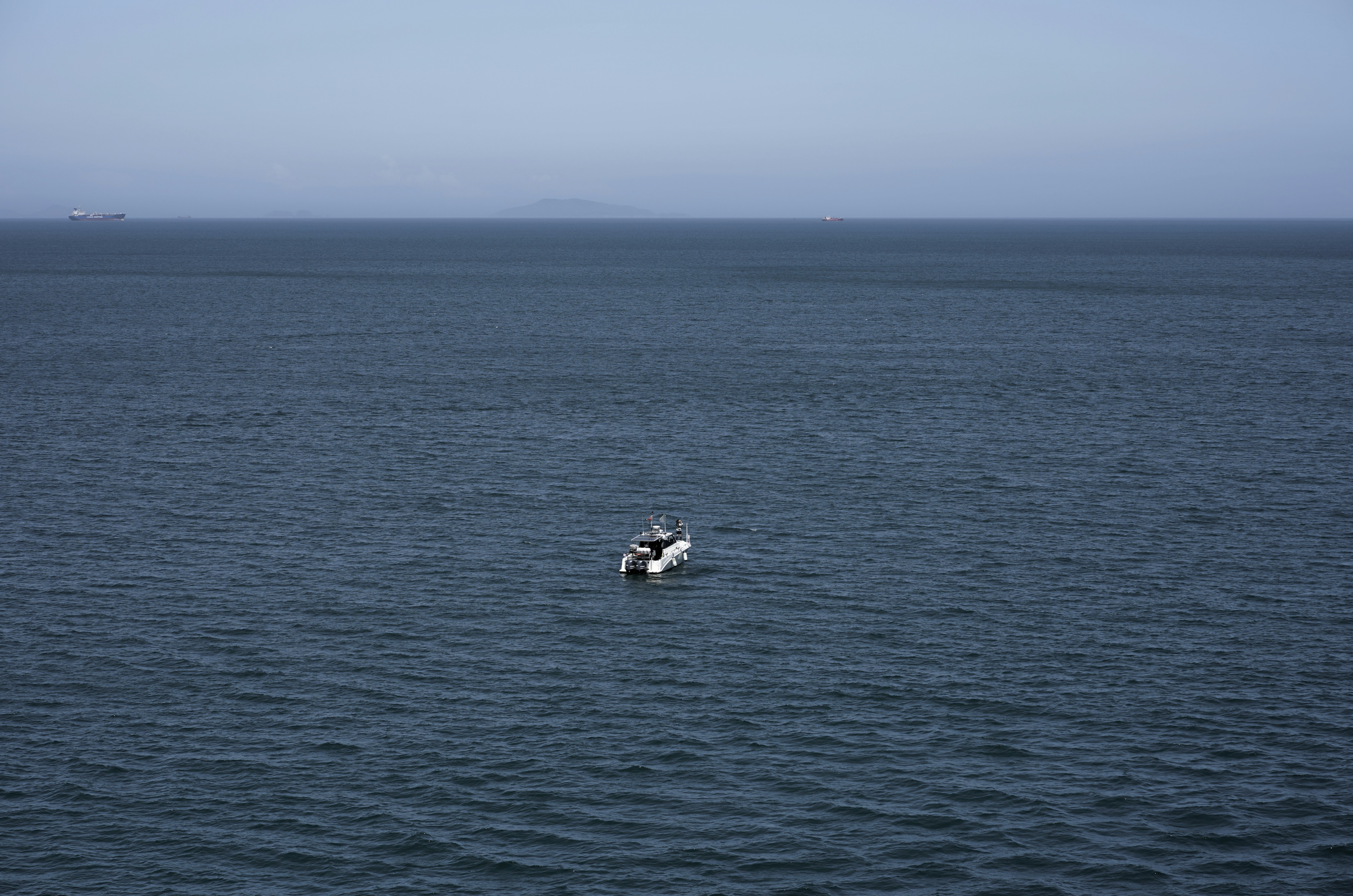 A boat floating on top of a large body of water photo – Free Mirs bay ...