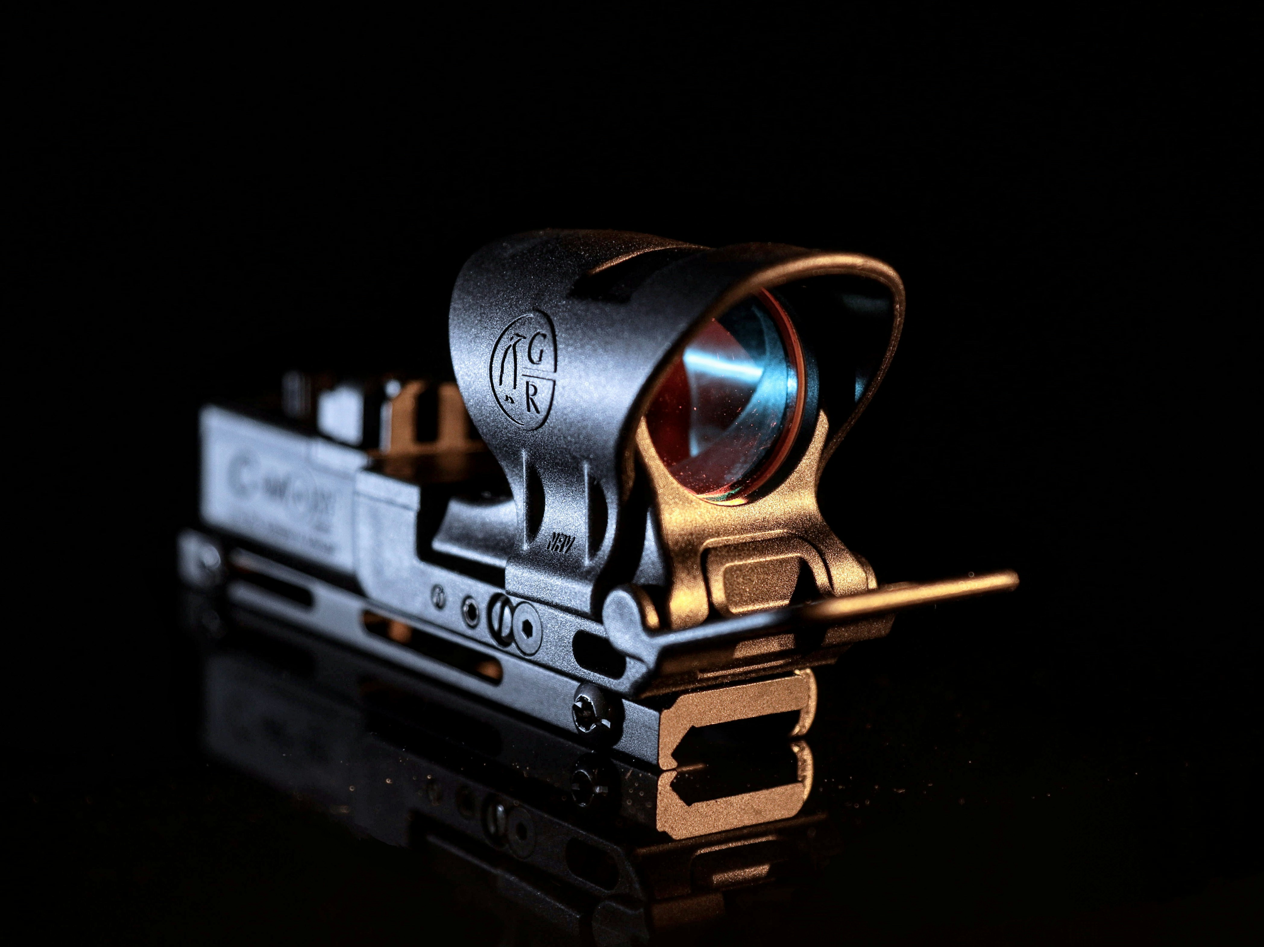 Aim High: Close-Up of a Minimalist Red Dot Sight on a Dark Stage