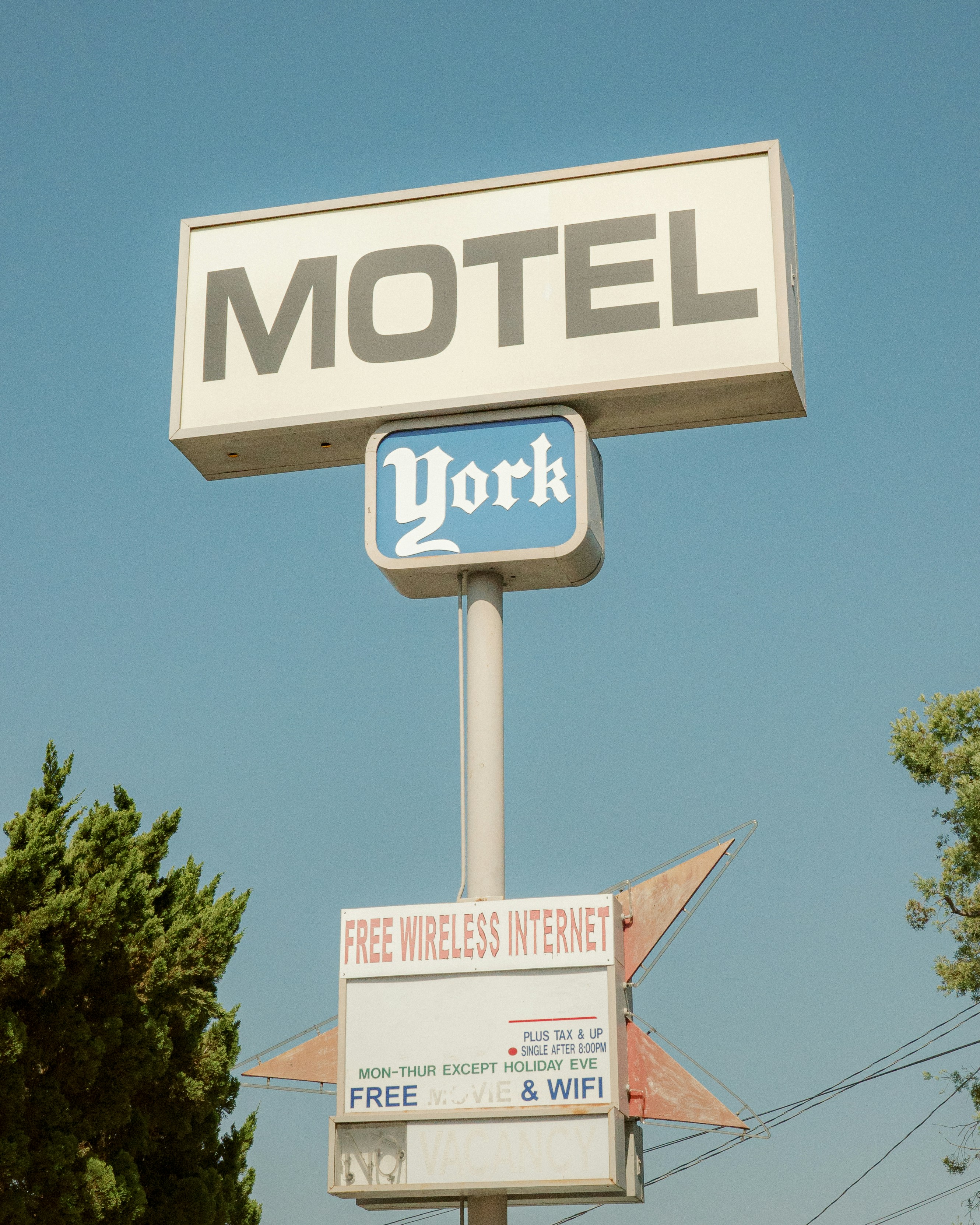 A motel sign with a free wireless internet sign below it photo – Free ...