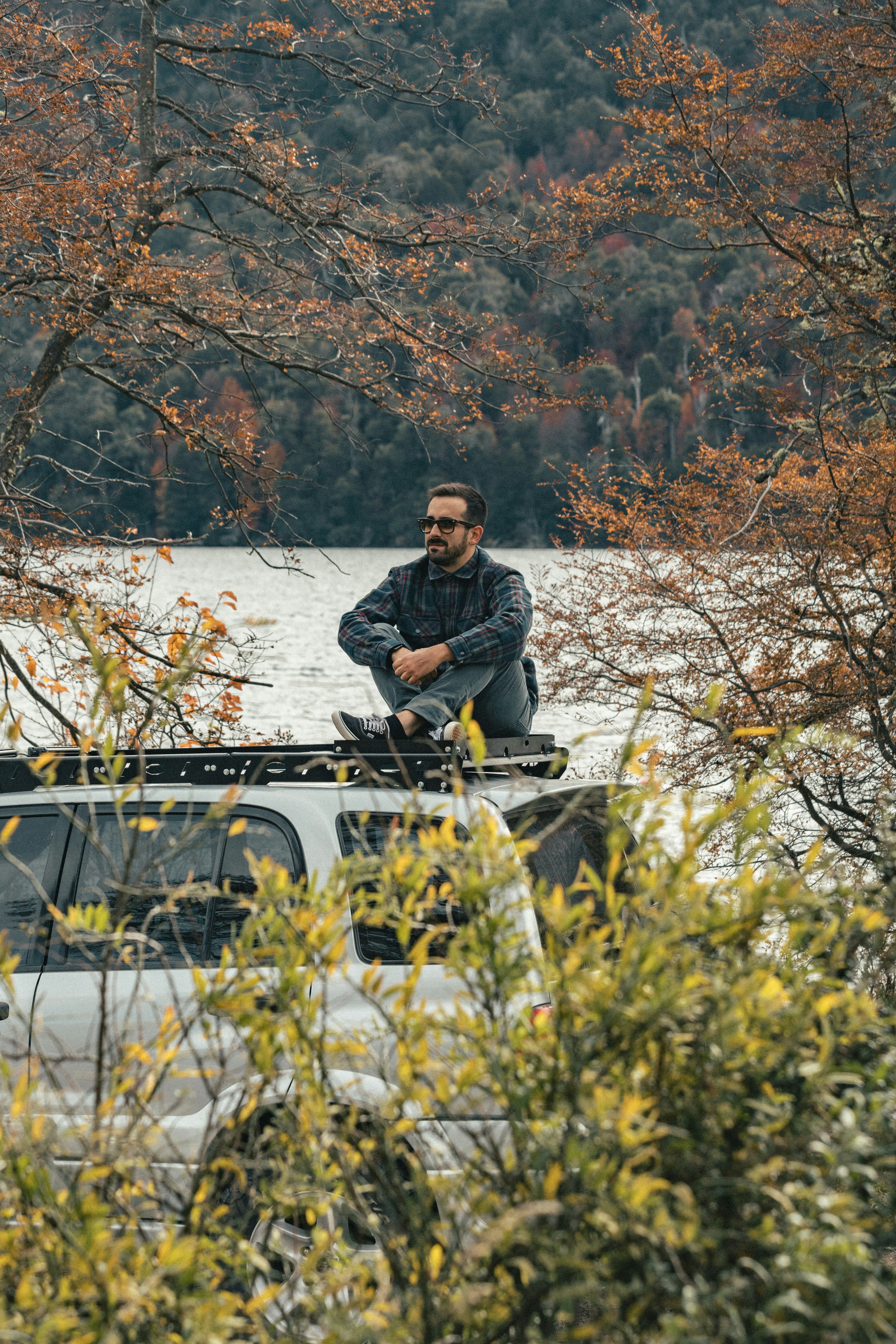 Autumn Quiet by the Lake: A Solitary Figure Perched on a Roof Rack