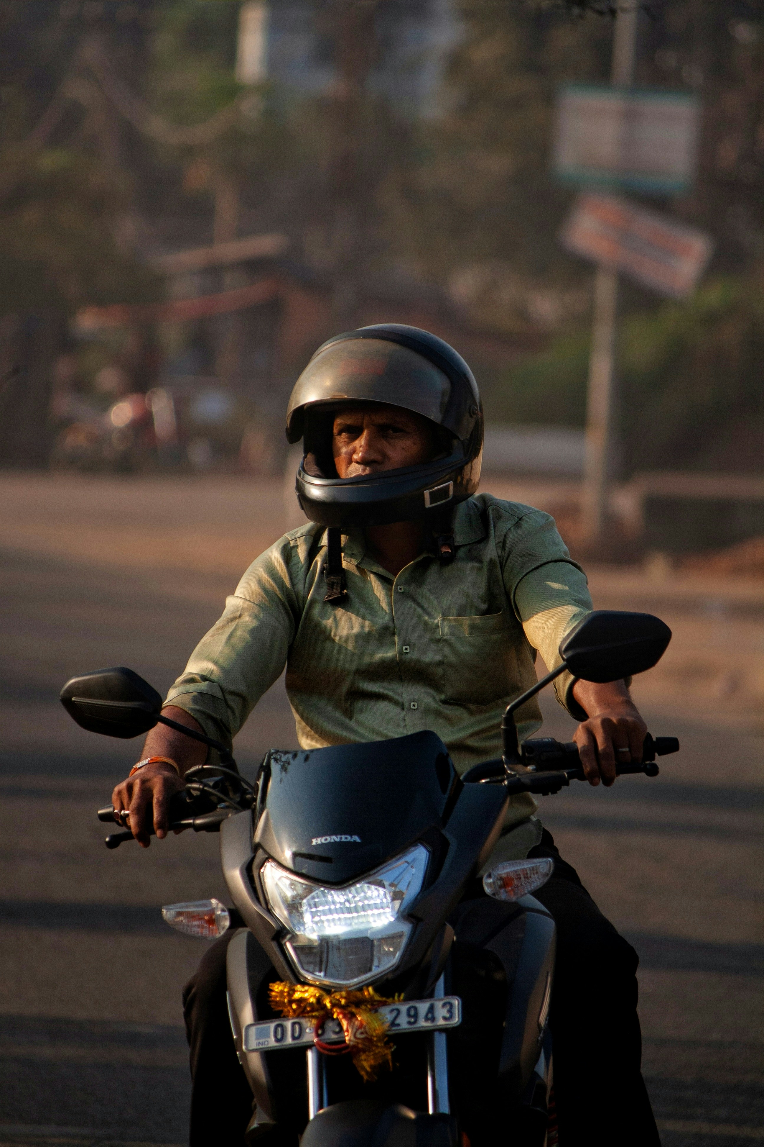 Front-Row Pulse: Helmeted Rider on a Honda on a Quiet Street at Dusk