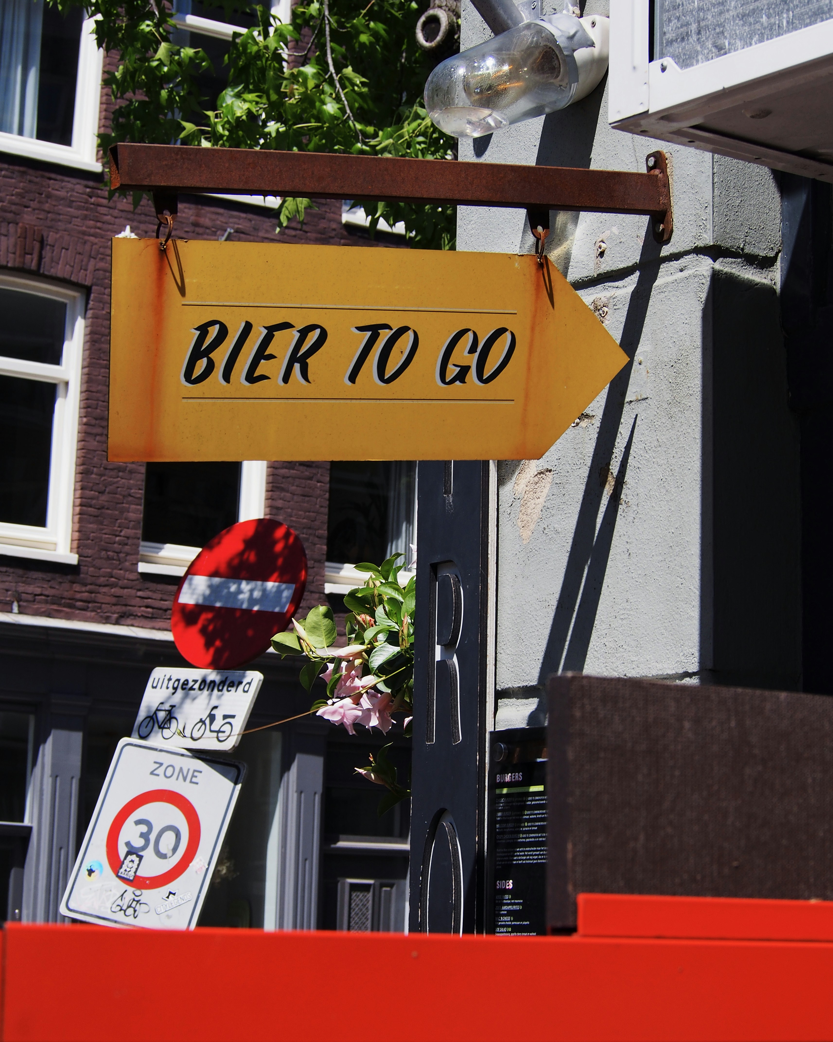 a yellow sign hanging from the side of a building