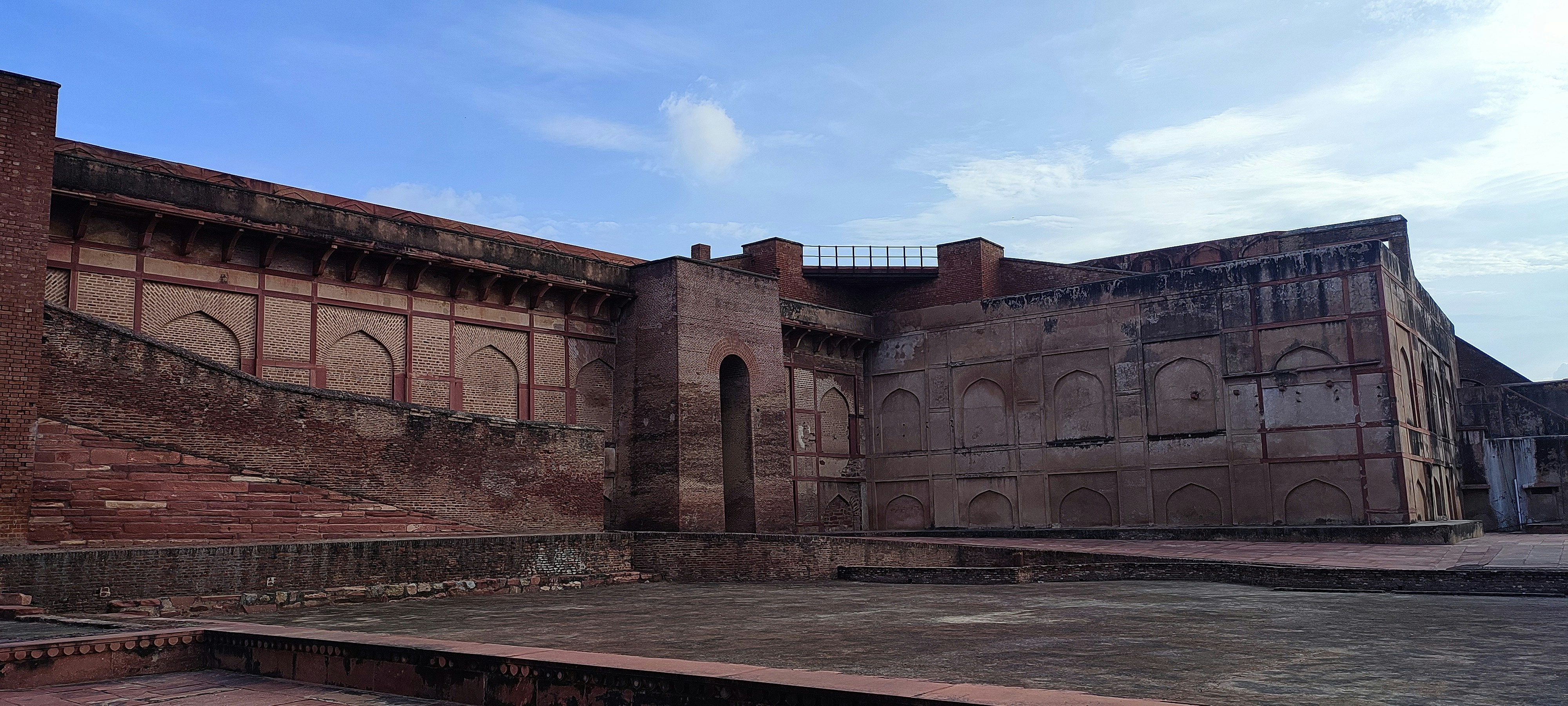 Arched Silence: Weathered Brick Fort Under a Wide Blue Sky