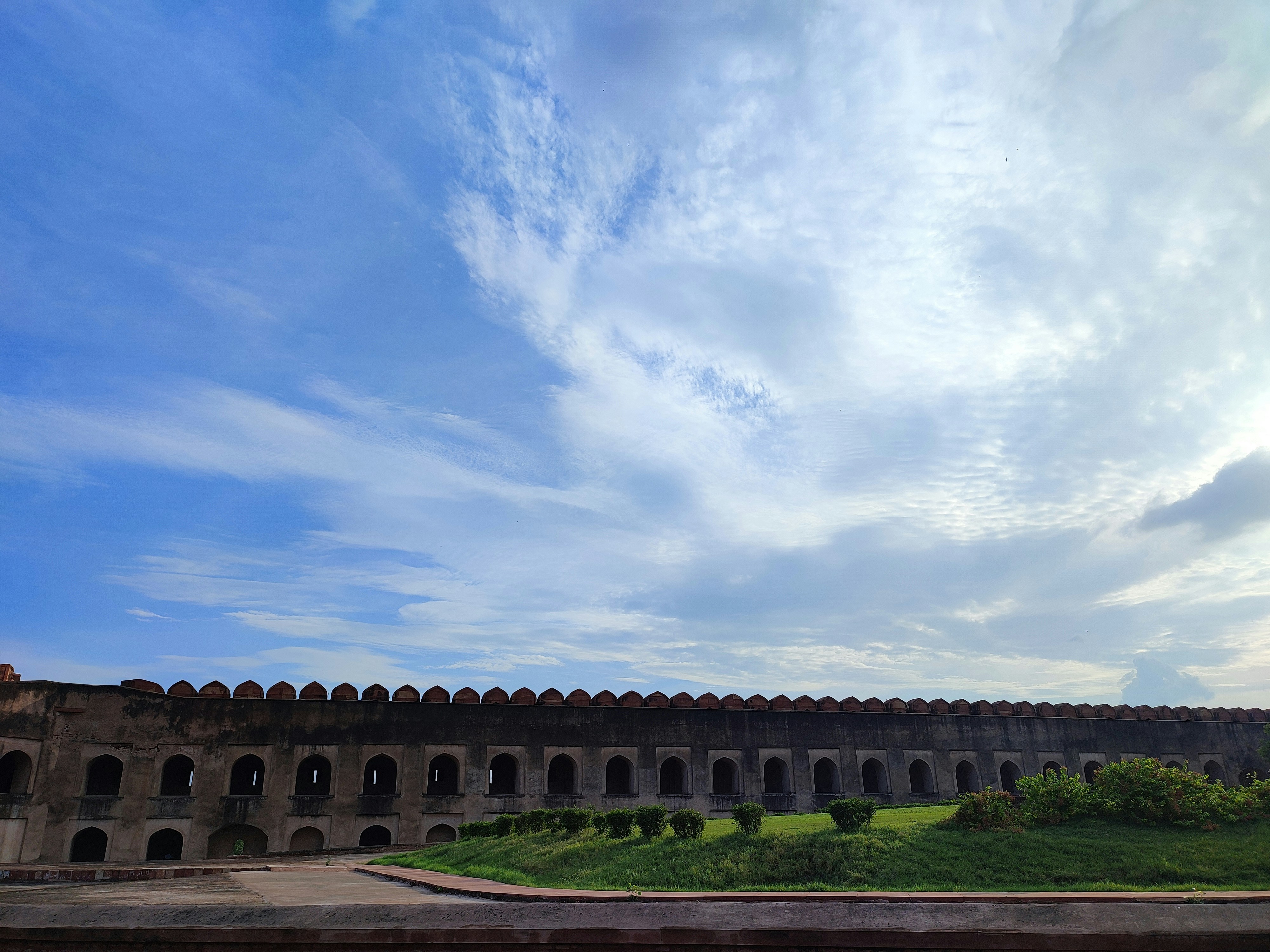 Ancient Arcade Lined with Green Slopes under a Blue Sky