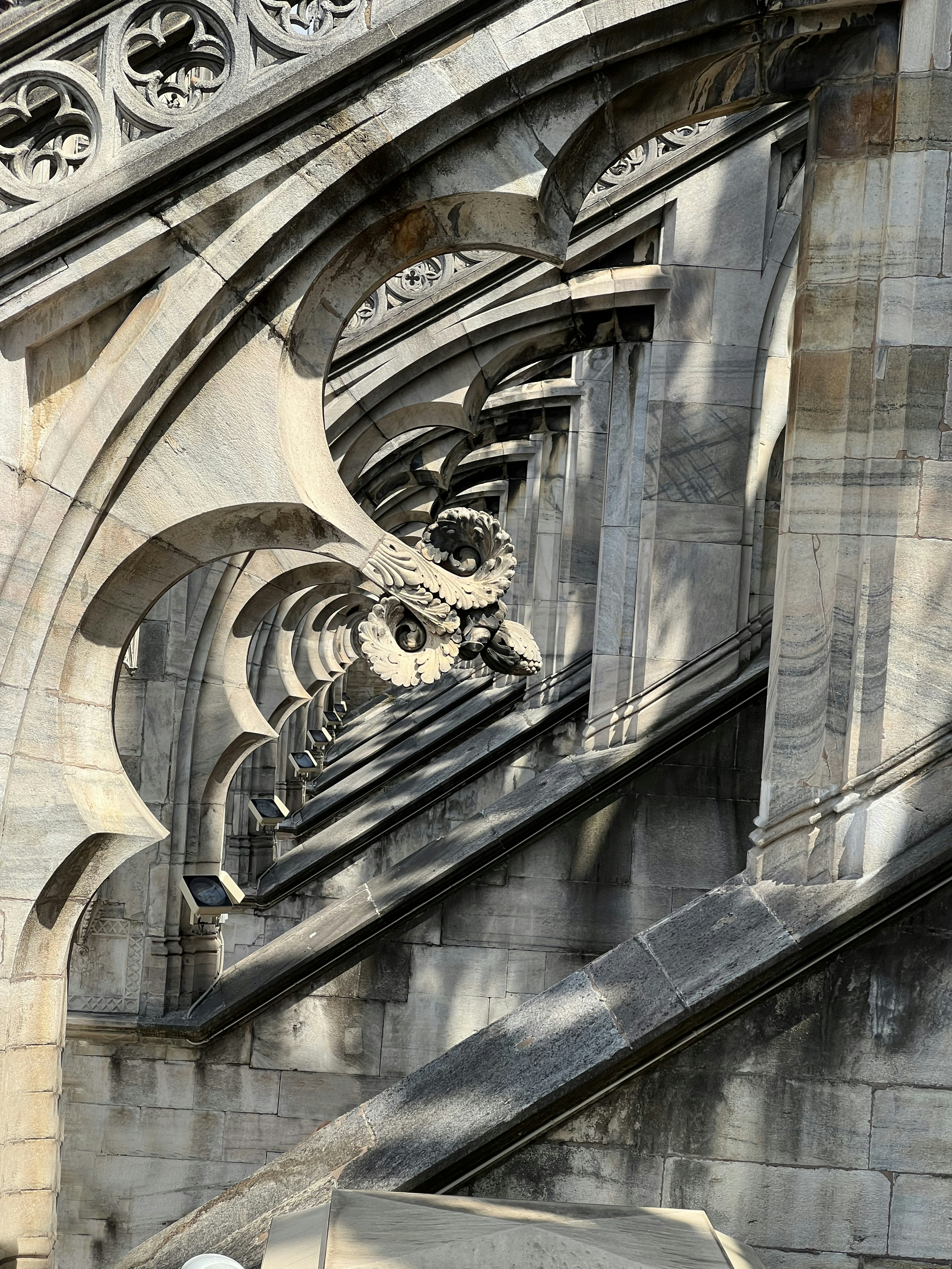 Gothic Arches and Stone Scrollwork on a Sunlit Stairway