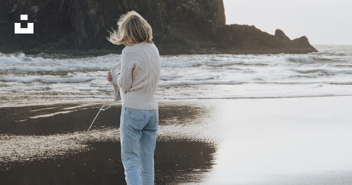 Una Mujer Parada En La Cima De Una Playa Junto Al Océano Foto Imagen