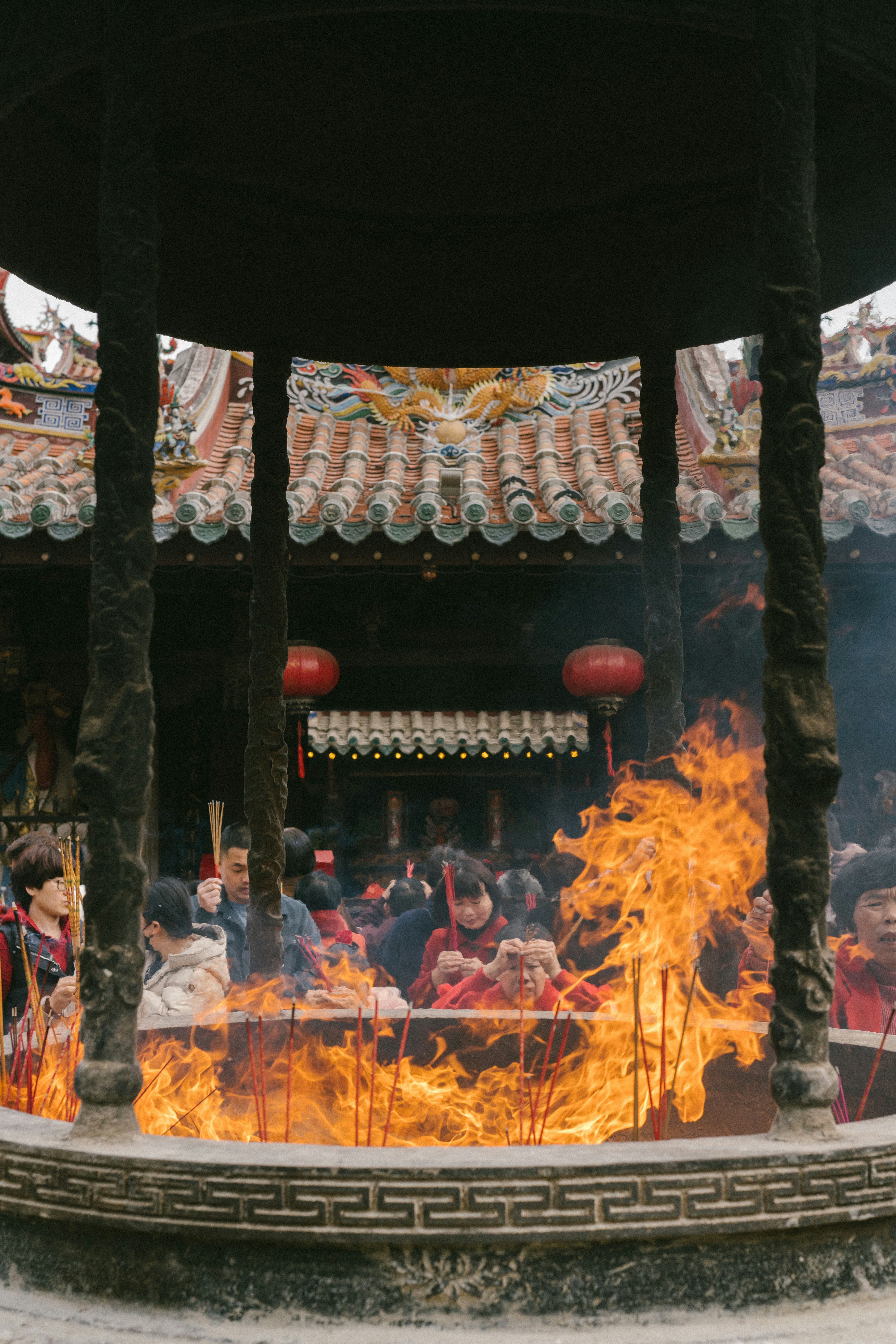Firelit Temple Courtyard: Ritual Flames Behind Ornate Roofs