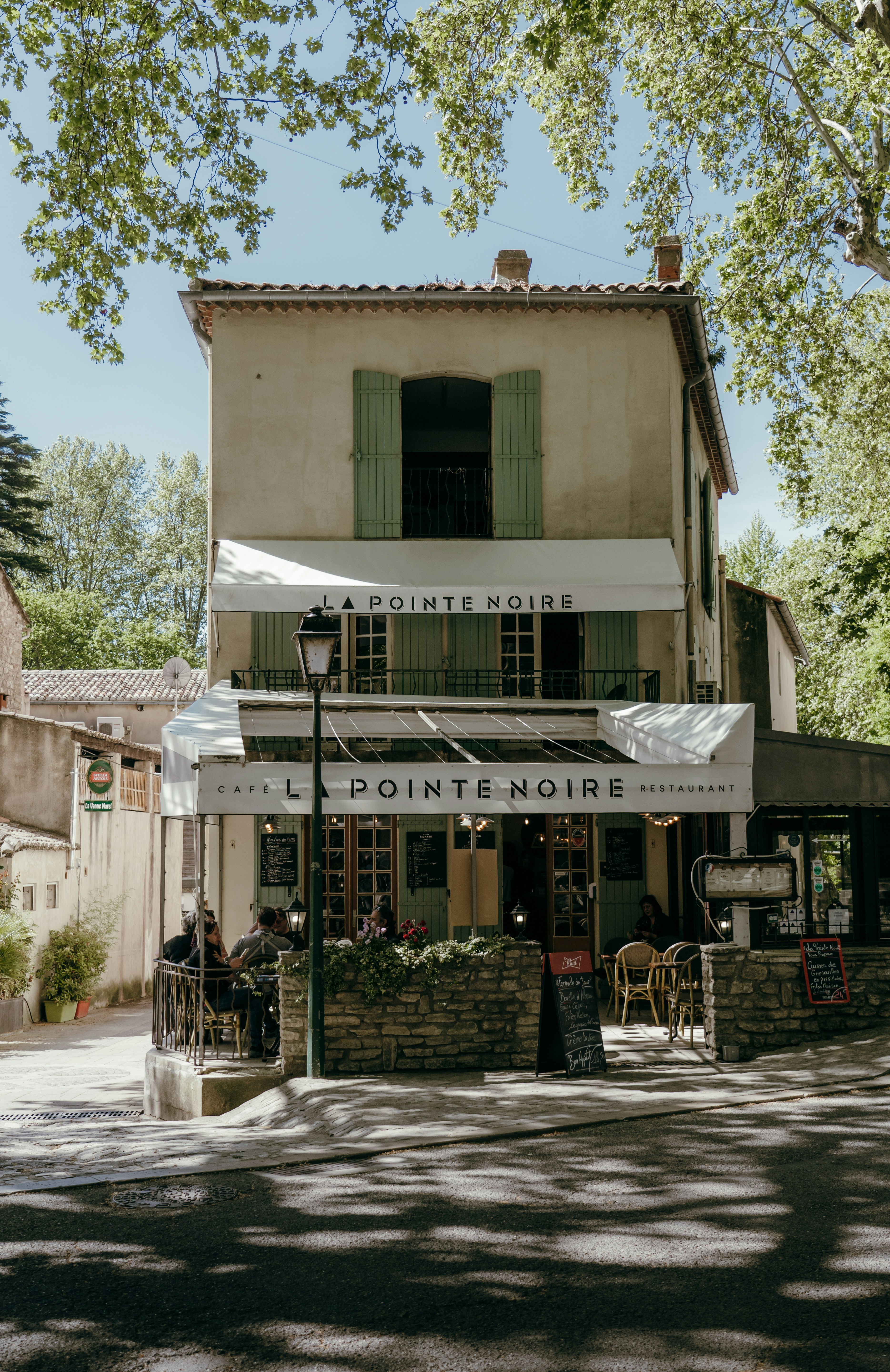 Un coin de rue avec un bâtiment et des arbres photo – Photo Ville ...