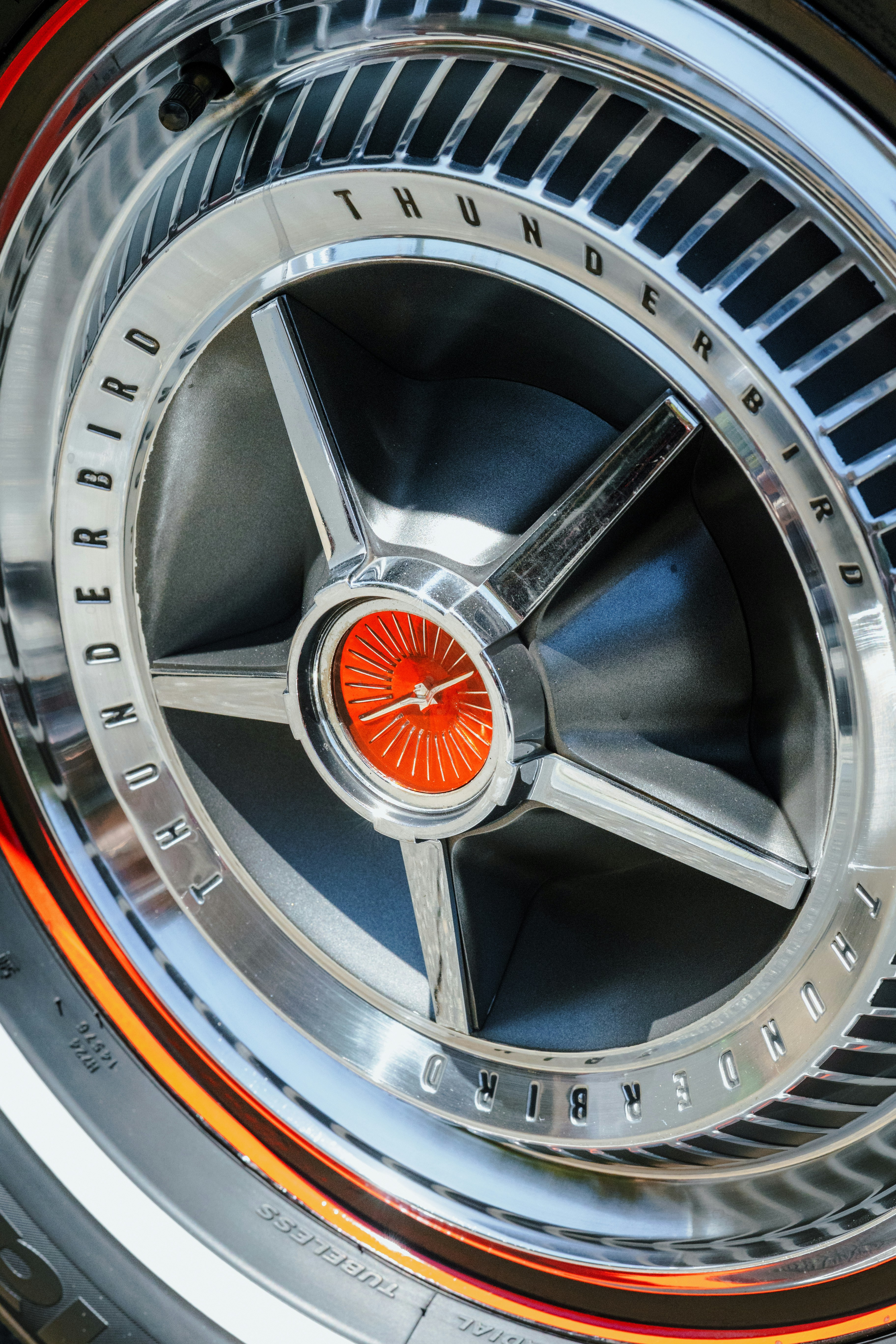 Rear wheel chrome detail with red center emblem on a Thunderbird hub