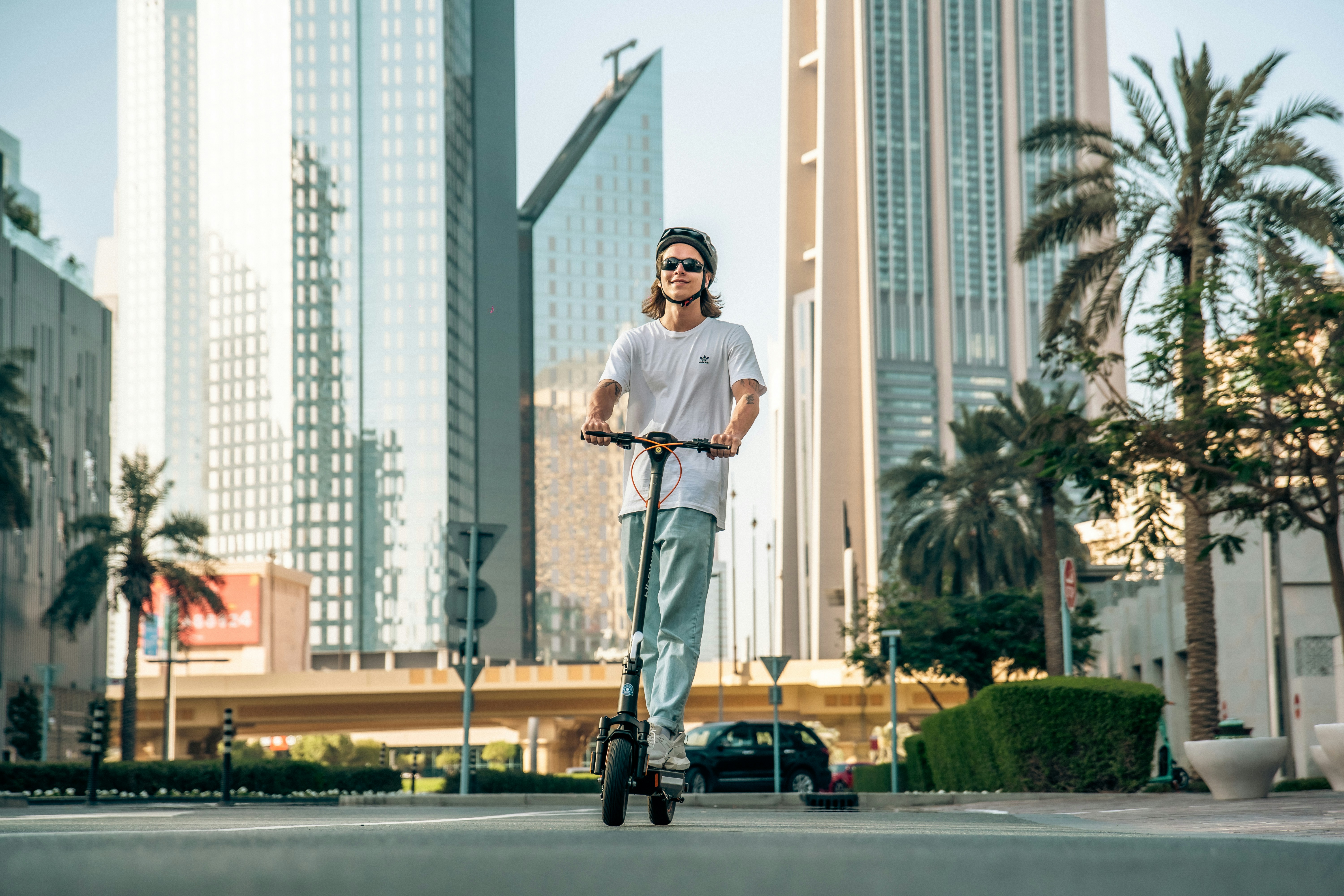 Urban Glide: Solo Rider Navigates Palm-Lined Downtown Beneath Glass Skyscrapers