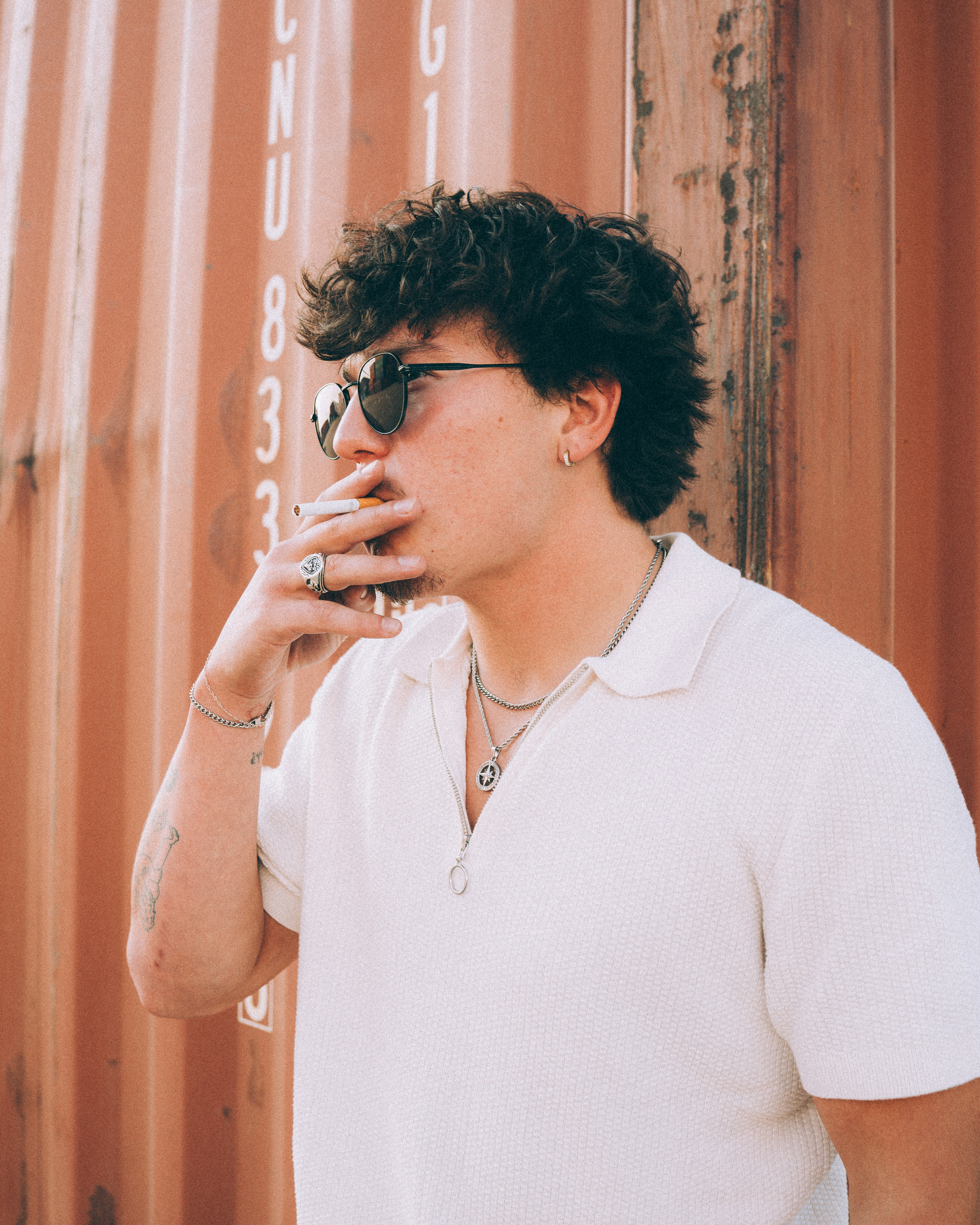 A man smoking a cigarette in front of a rusty wall photo – Free Person ...