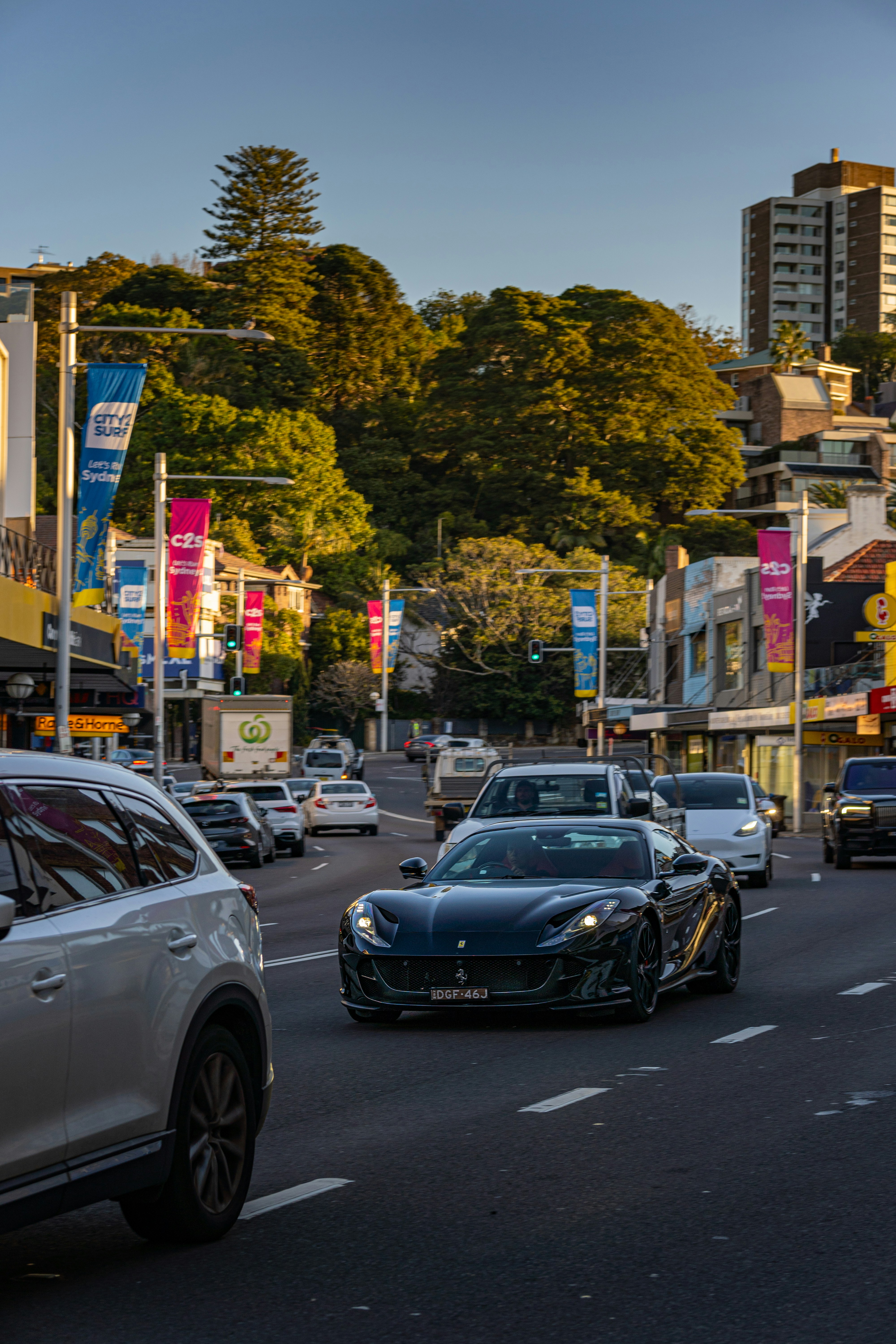 Velocity in the Ville: a black sports car threads a sunlit city boulevard